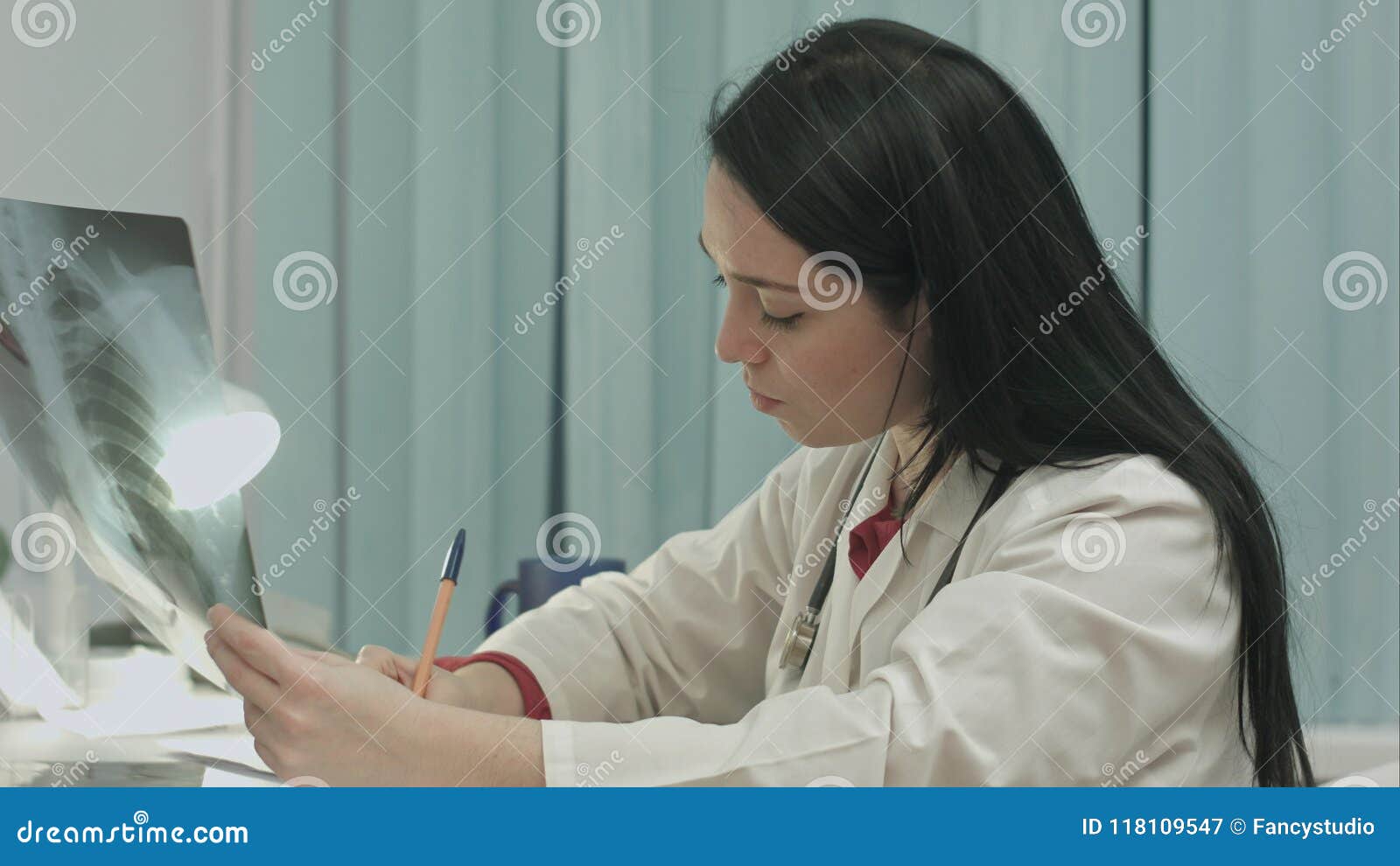 Female X-ray Technician Analyzing Some Results and Taking Notes Stock ...