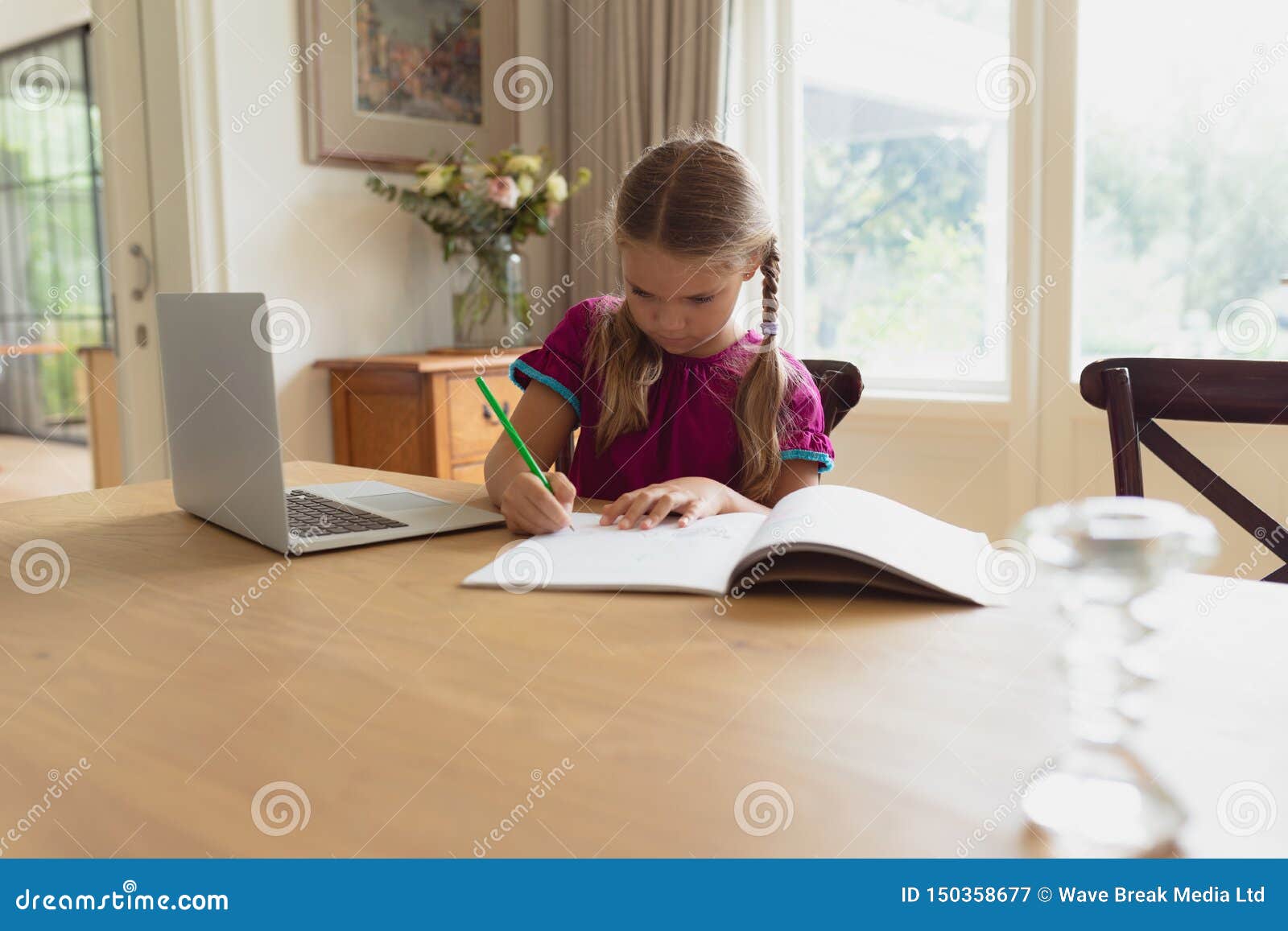 Cute Girl Doing Homework at Dining Table in a Comfortable Home Stock ...