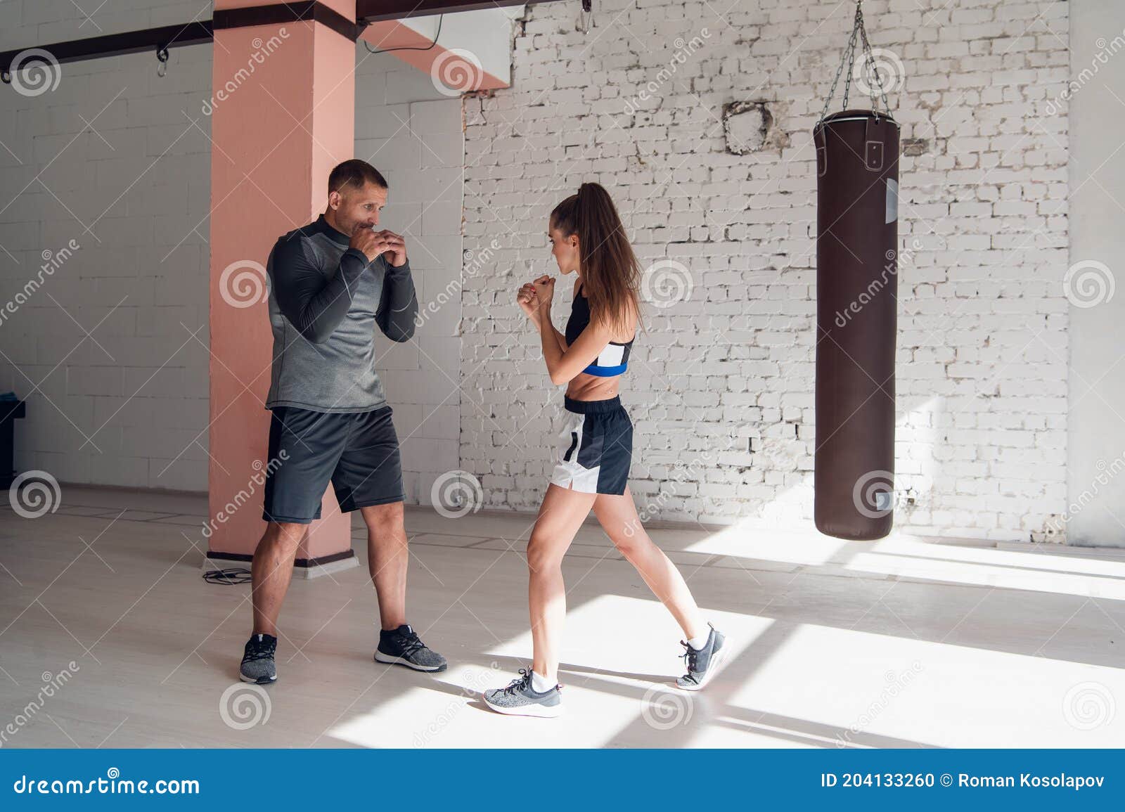 Cute Girl Learns Kickboxing Techniques in the Gym with an Experienced ...