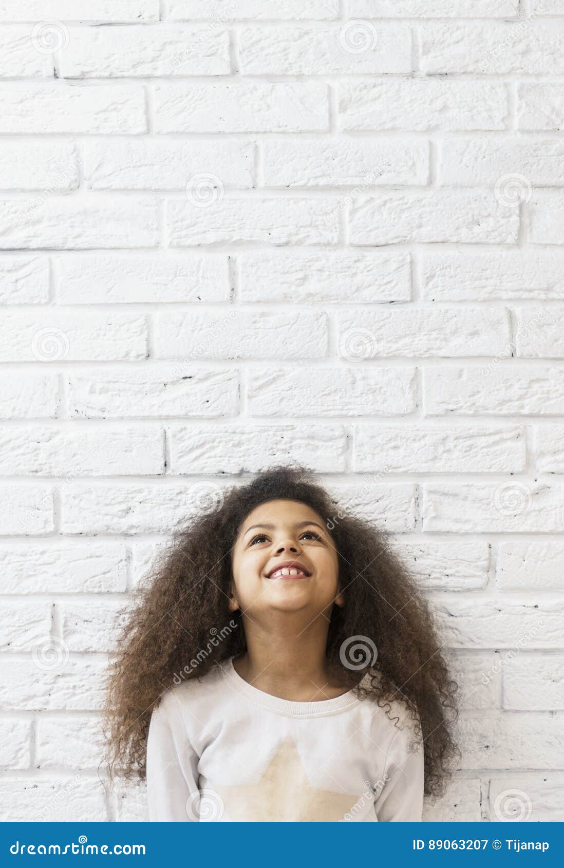 Cute Girl Over a Brick Wall Looking Up Stock Image - Image of mixed ...