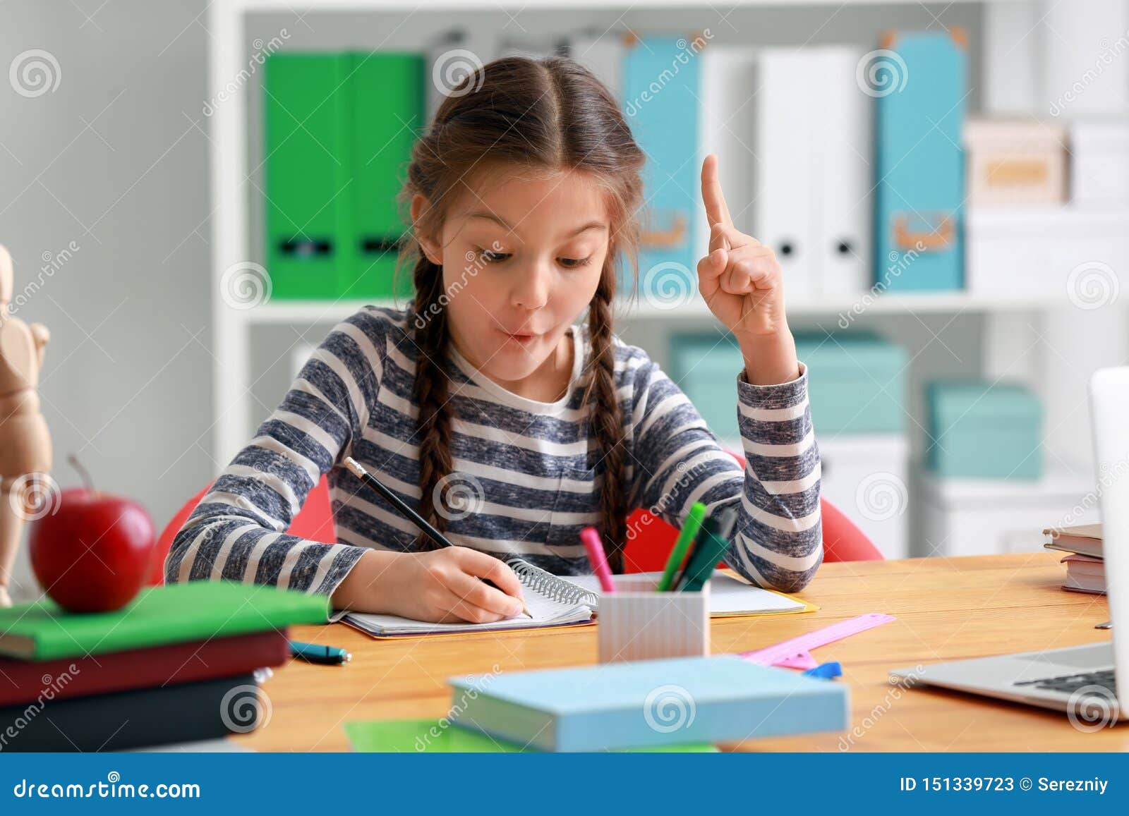 Cute Girl with Raised Index Finger Doing Homework in Classroom Stock ...