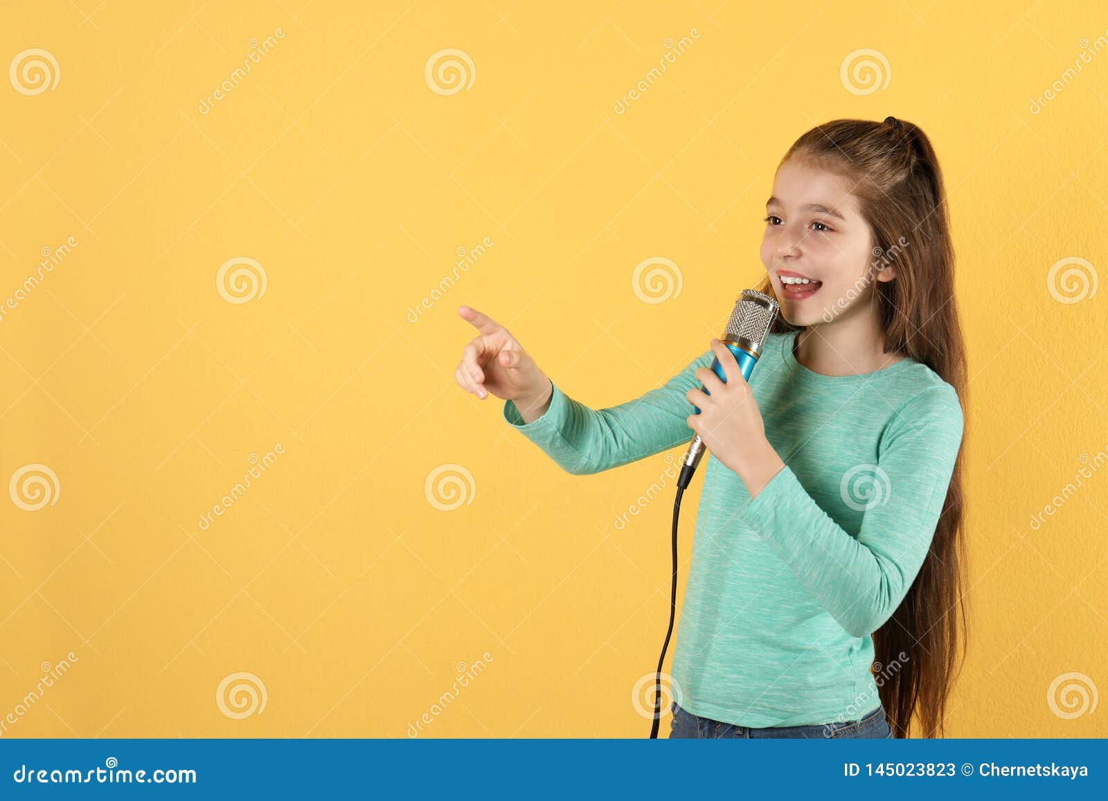Cute Girl Singing in Microphone on Color Background Stock Image - Image ...