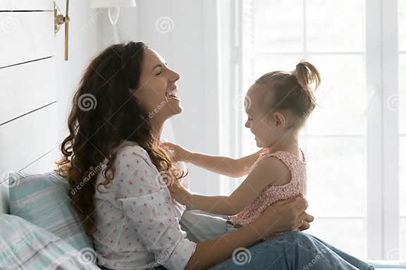 Cute Girl Sits On Mommy Laps Enjoy Playtime On Bed Stock Image Image Of Laughing Cute 296024995