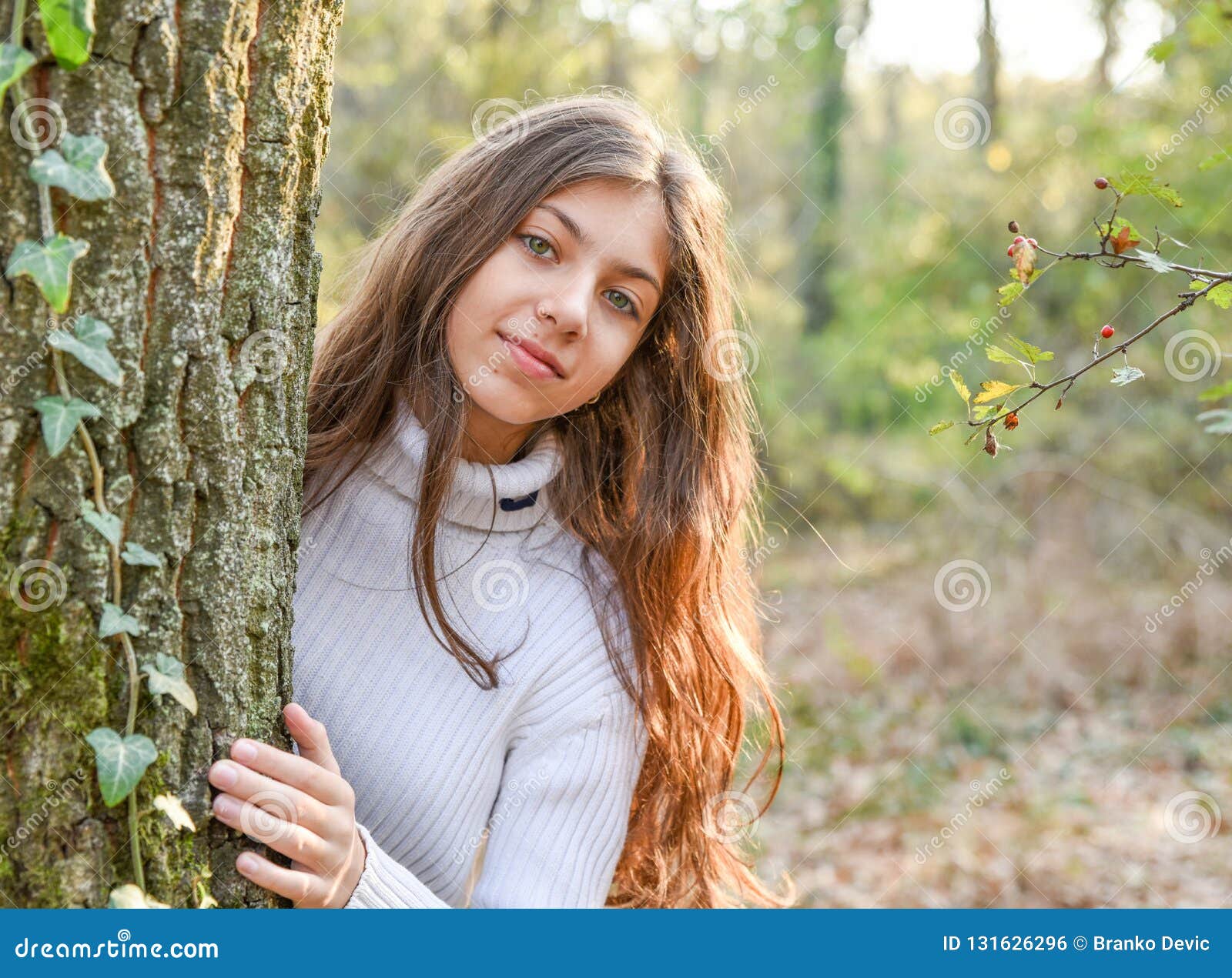 Cute Girl with Smile Standing Behind a Tree Stock Photo - Image of ...