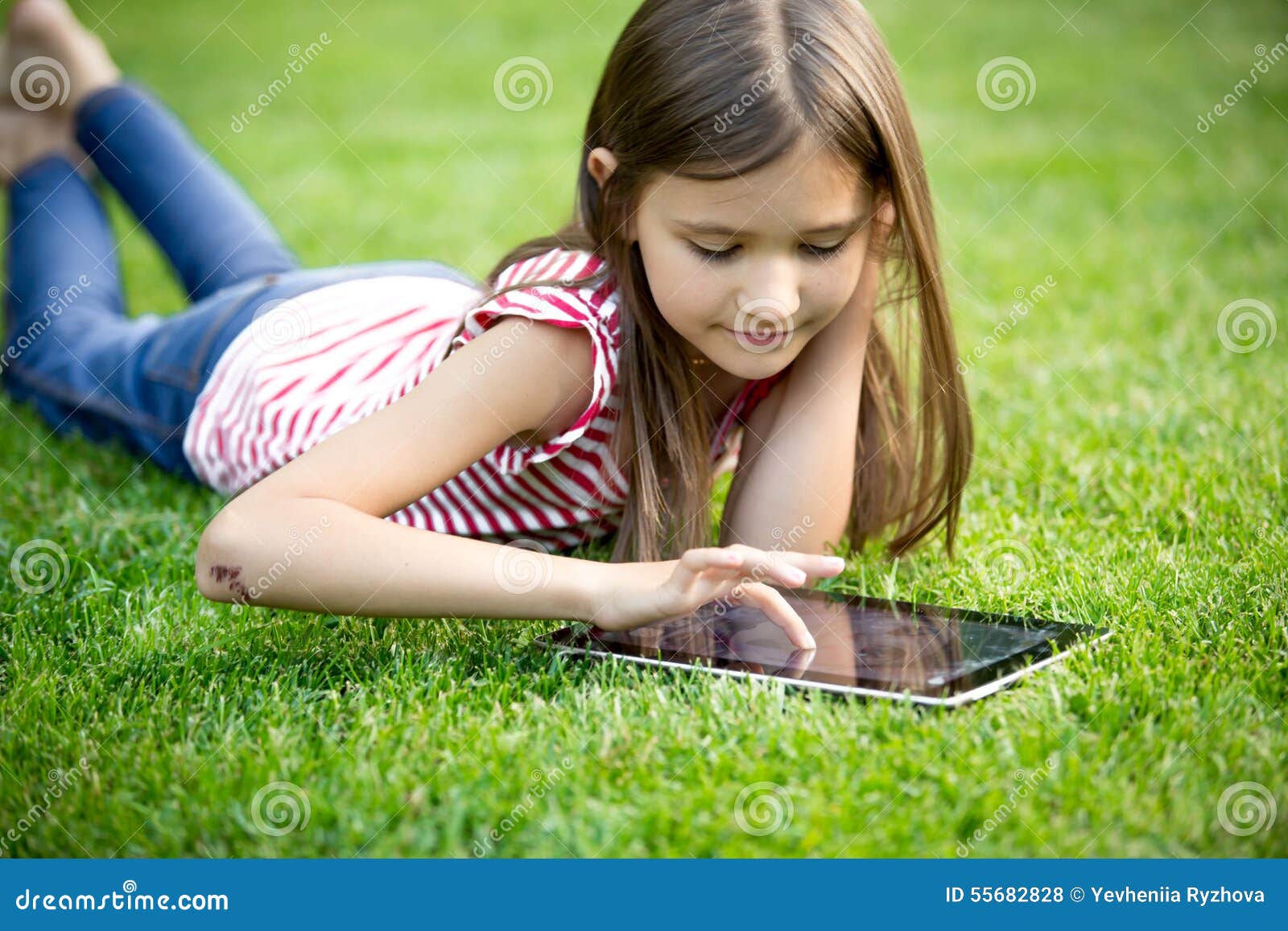 Cute Girl Using Digital Tablet at Park on Grass Stock Photo - Image of ...