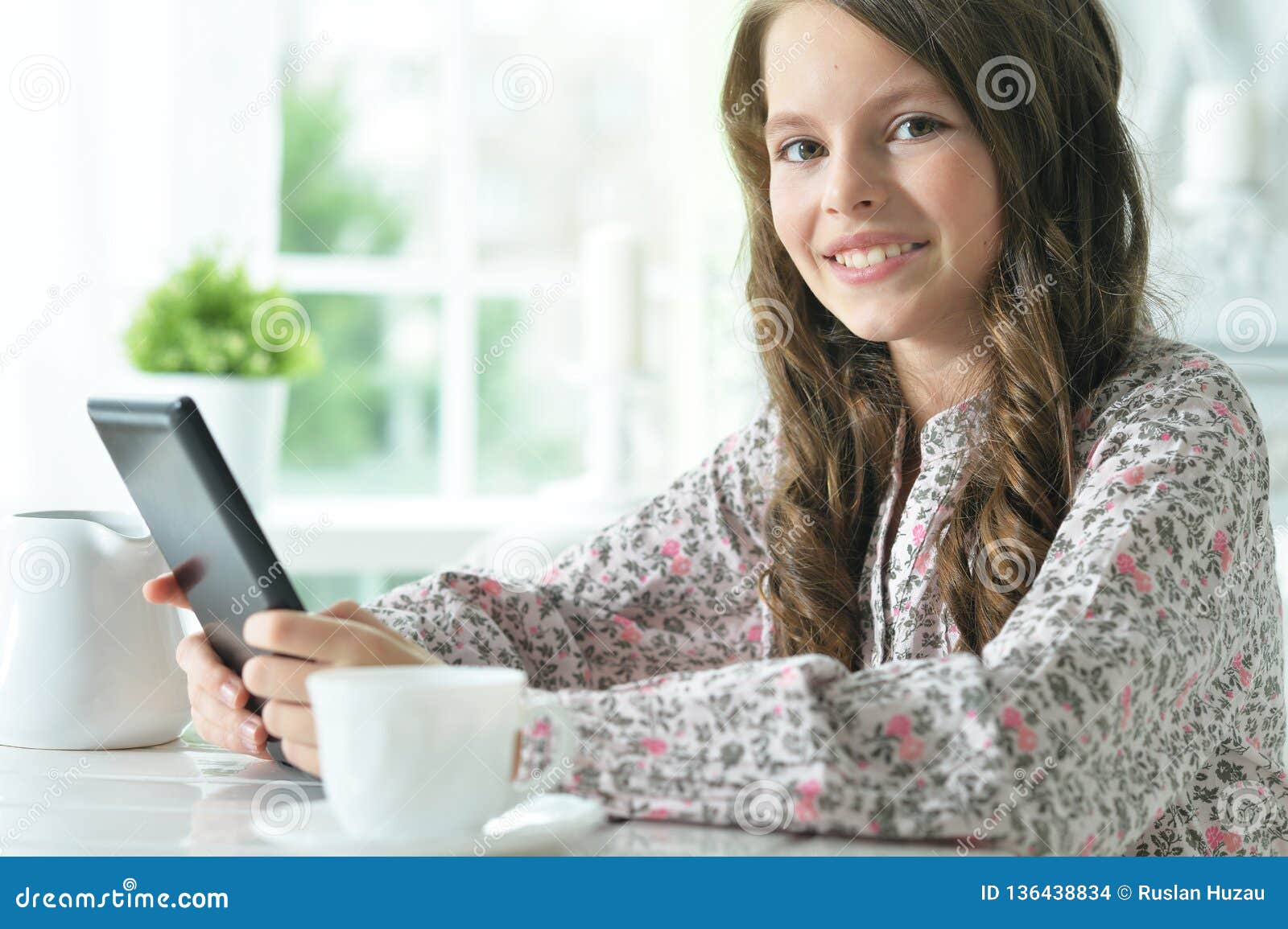 Portrait of Cute Girl Using Tablet while Drinking Tea at Light Kitchen ...