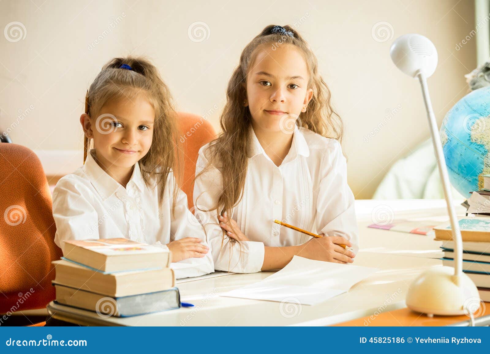 Cute Girls in School Uniform Sitting at Desk and Doing Homework Stock ...