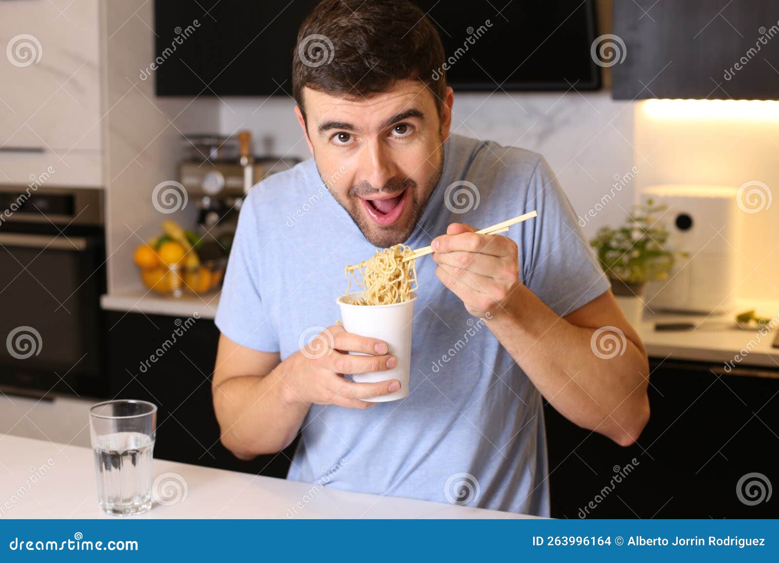 Cute Guy Eating Instant Noodles in the Kitchen Stock Photo - Image of ...