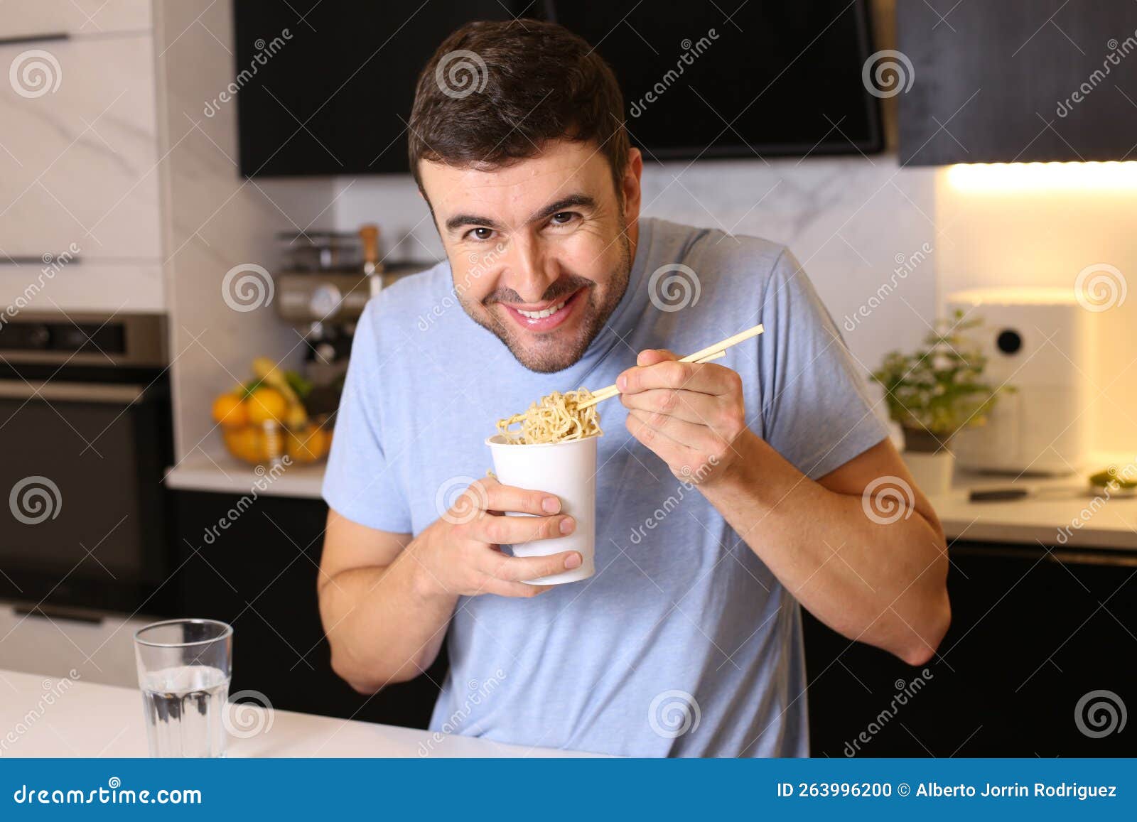 Cute Guy Eating Instant Noodles in the Kitchen Stock Photo - Image of ...