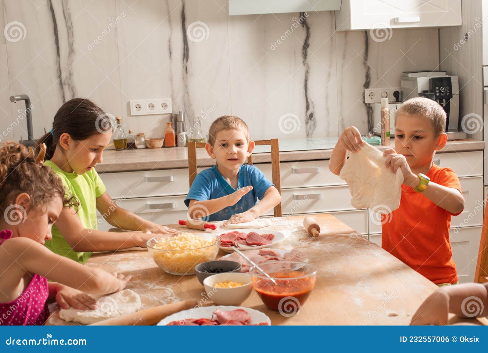 The Cute Kids Sit at a Table in the Kitchen and Make Pizza Stock Photo ...
