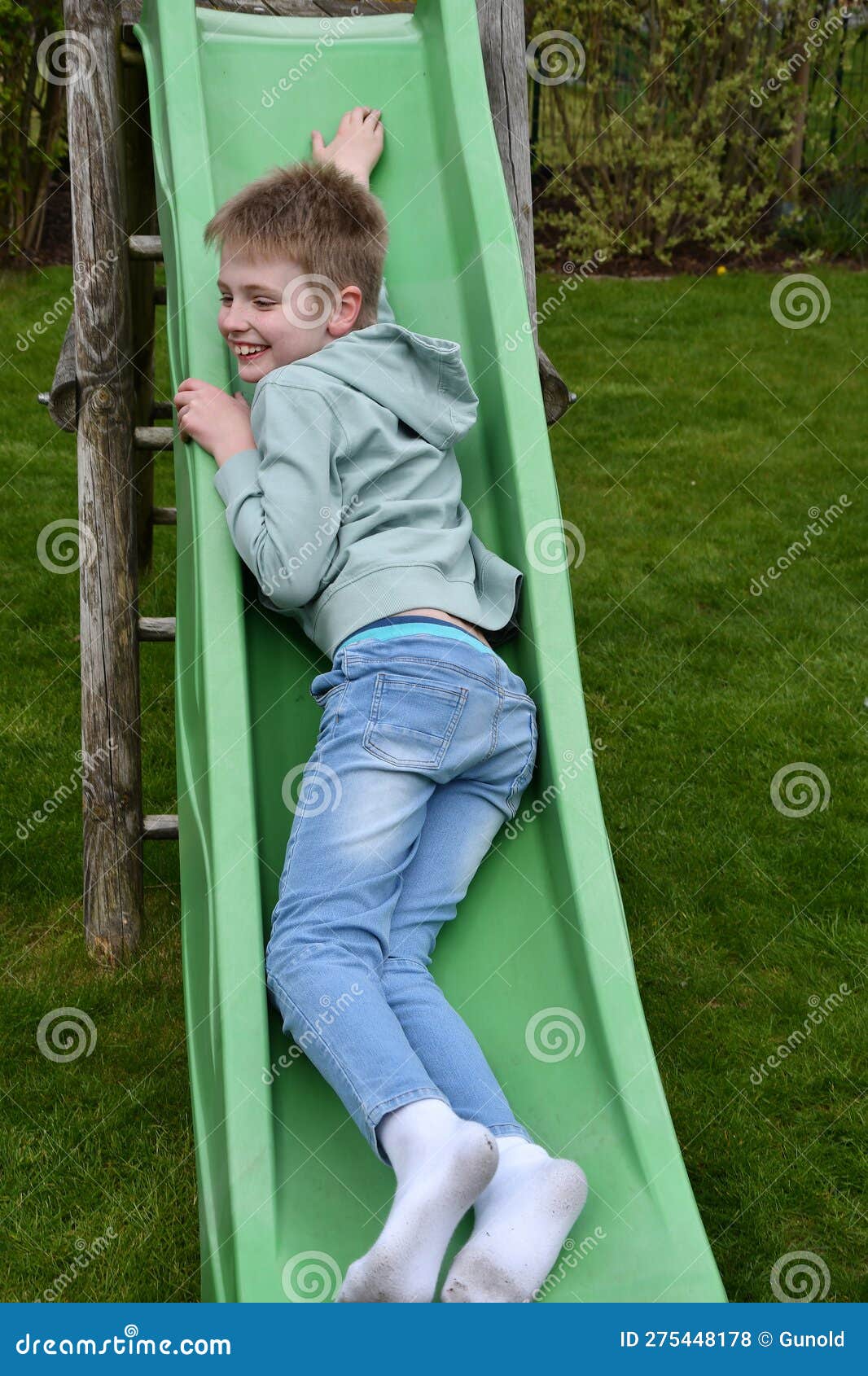 Cute lboy plays on a slide stock photo. Image of happiness - 275448178