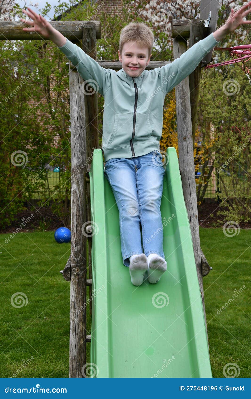 Cute lboy plays on a slide stock photo. Image of laugh - 275448196