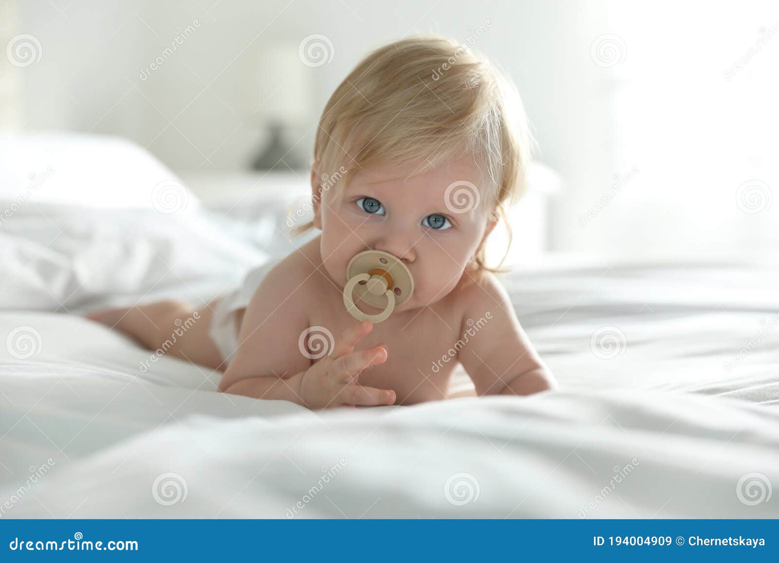 Cute Little Baby in Diaper with Pacifier Lying on Bed Stock Image ...
