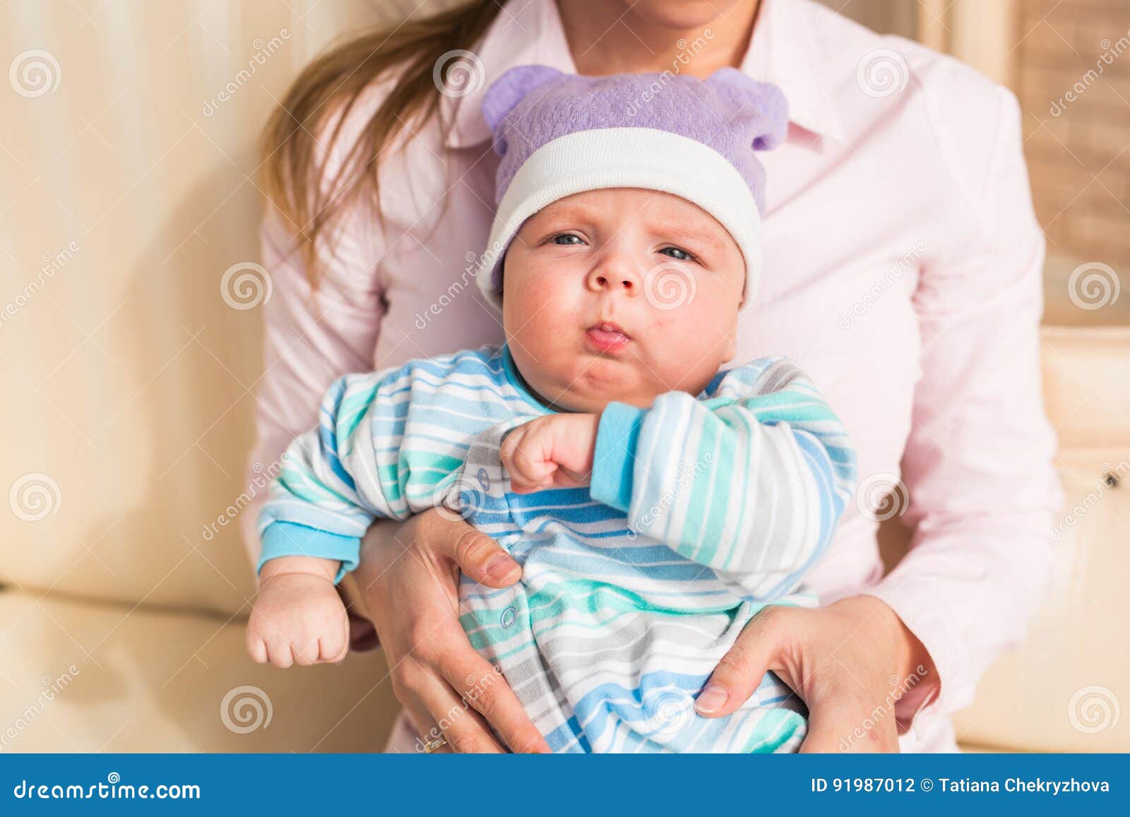A Cute Little Baby is Looking into the Camera and is Wearing a Purple ...