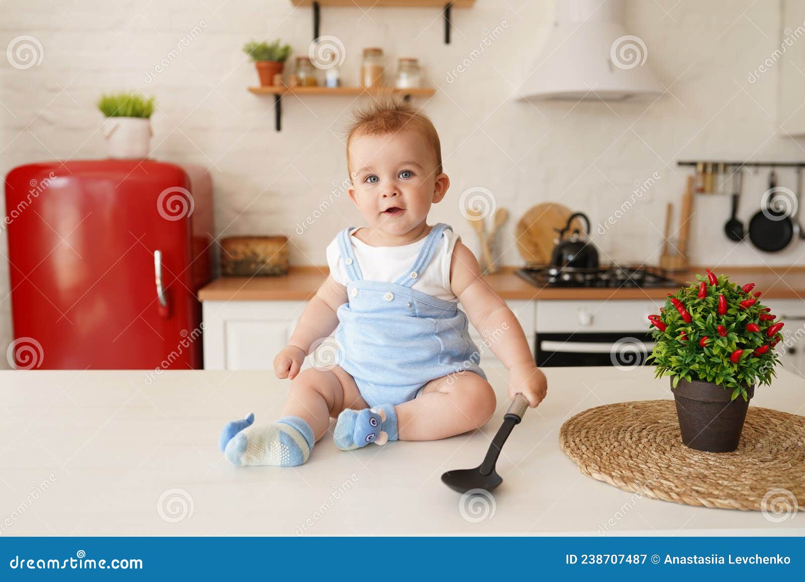 Cute Little Baby Sitting on Kitchen Table and Looking at Camera Stock ...