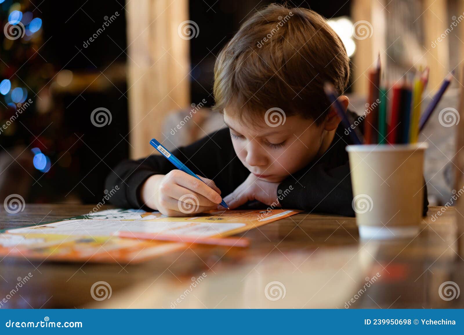 Cute Little Boy Drawing with Colour Pencils Sitting at the Table in ...