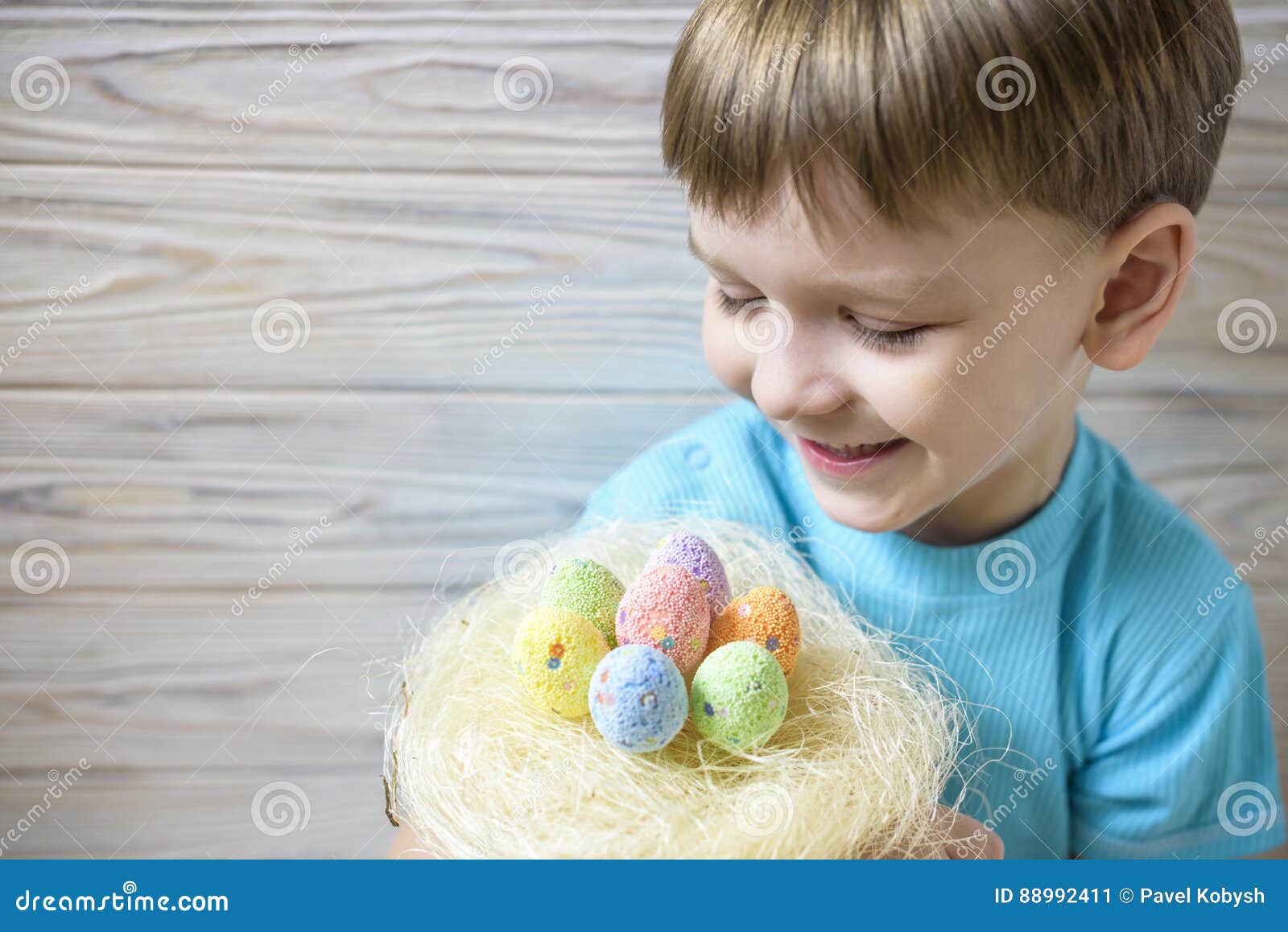 Cute Little Boy Holding a Nest with Colored Easter Eggs at Home on ...
