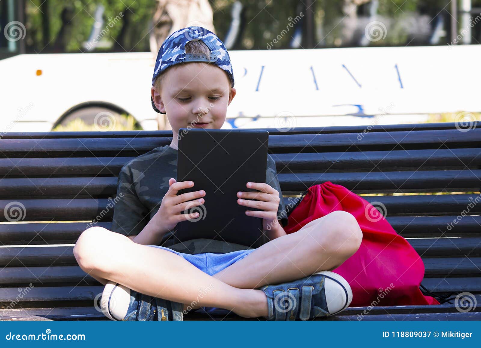 Boy is Playing in the Tablet on a Bench Stock Image - Image of looks ...