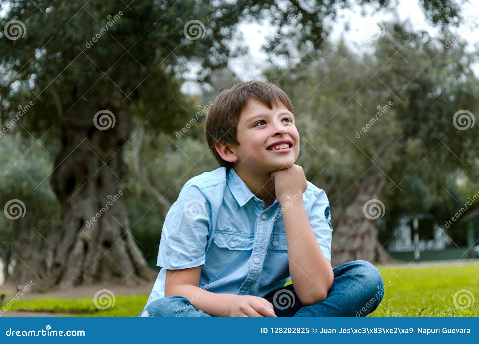 Cute Little Boy Sitting in the Park Smiling Thinking Stock Image ...