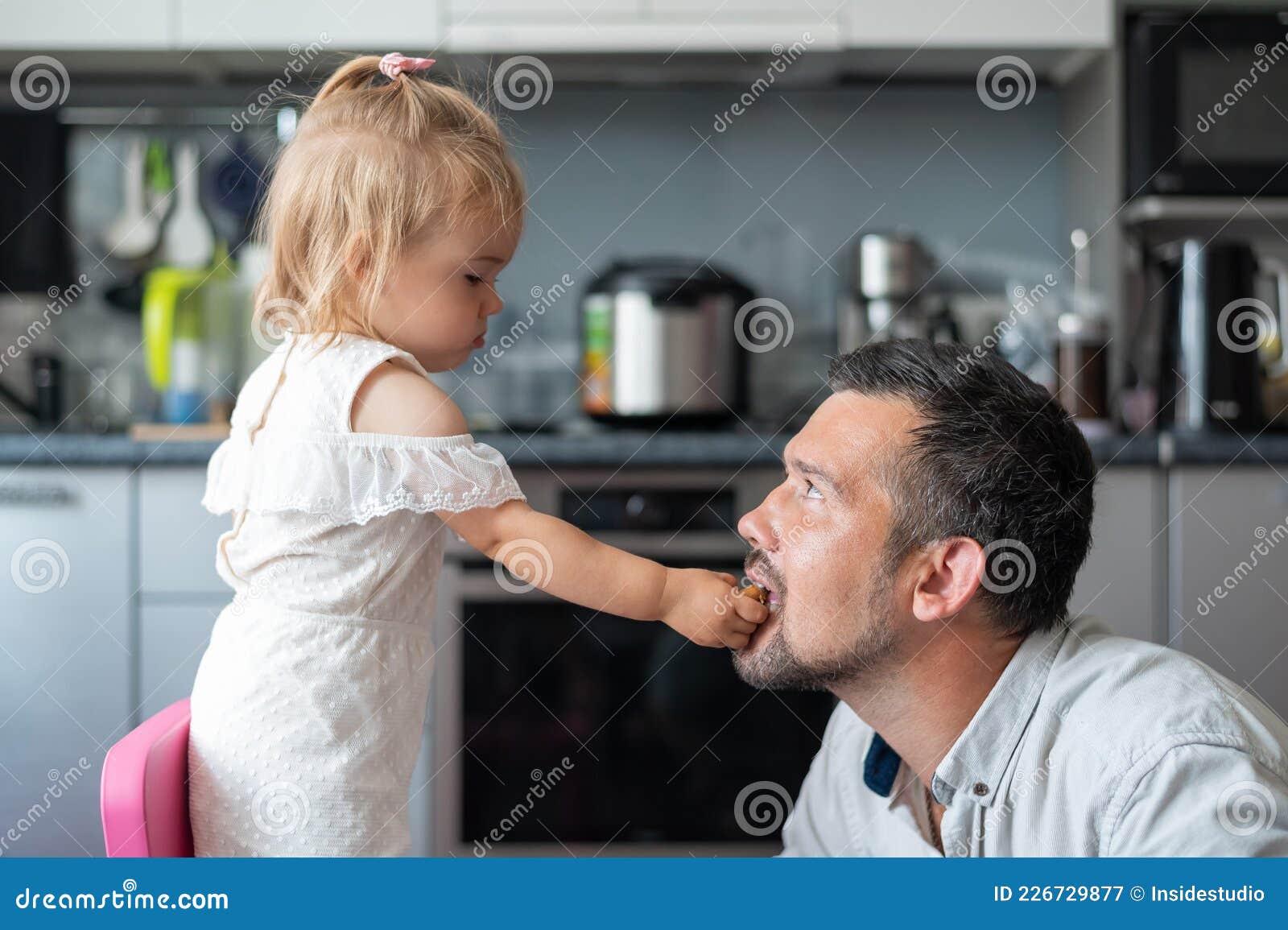 Cute Little Girl is Feeding Her Dad in the Kitchen Stock Image - Image ...