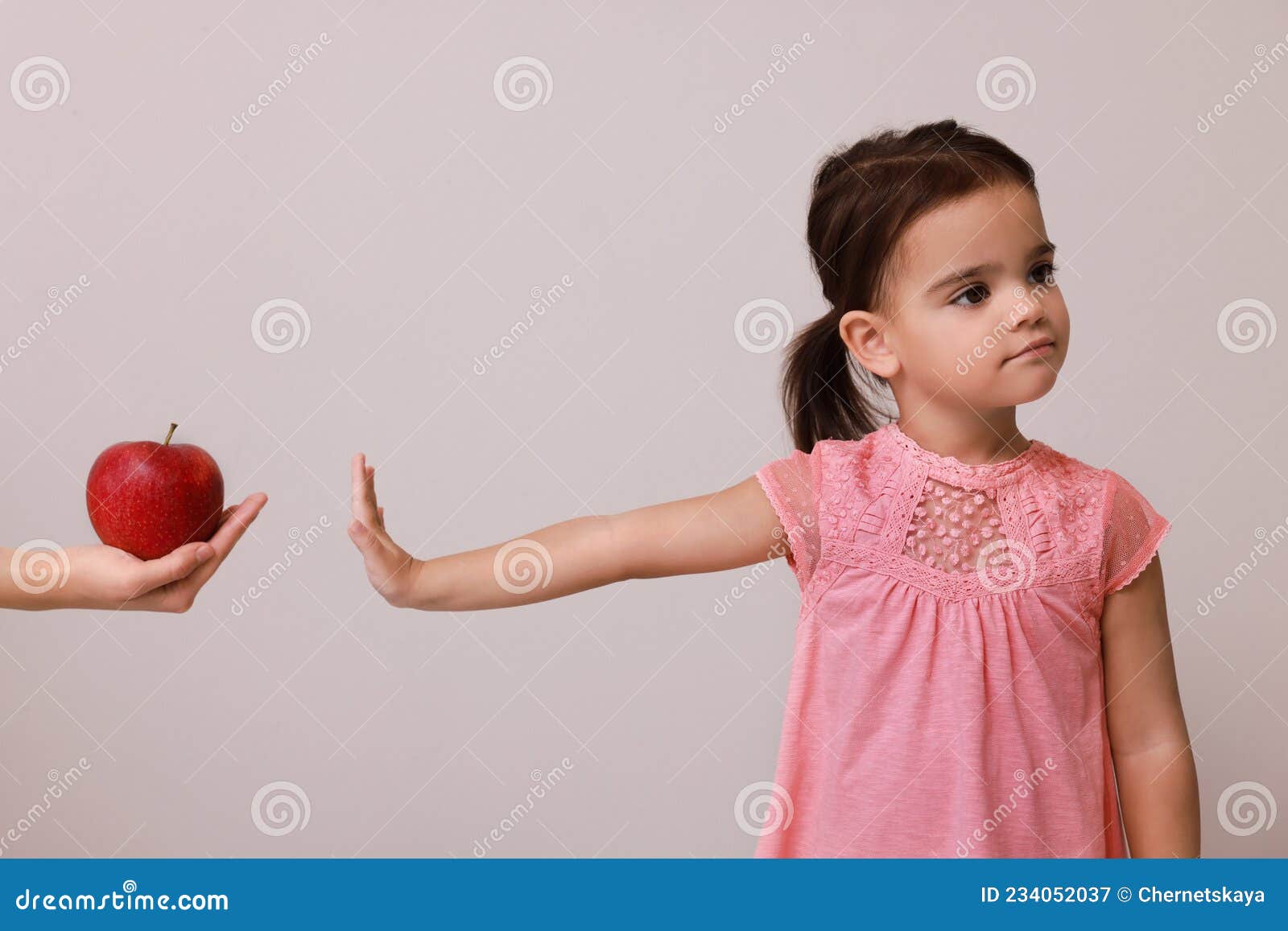 Cute Little Girl Refusing To Eat Apple on Grey Background Stock Image ...
