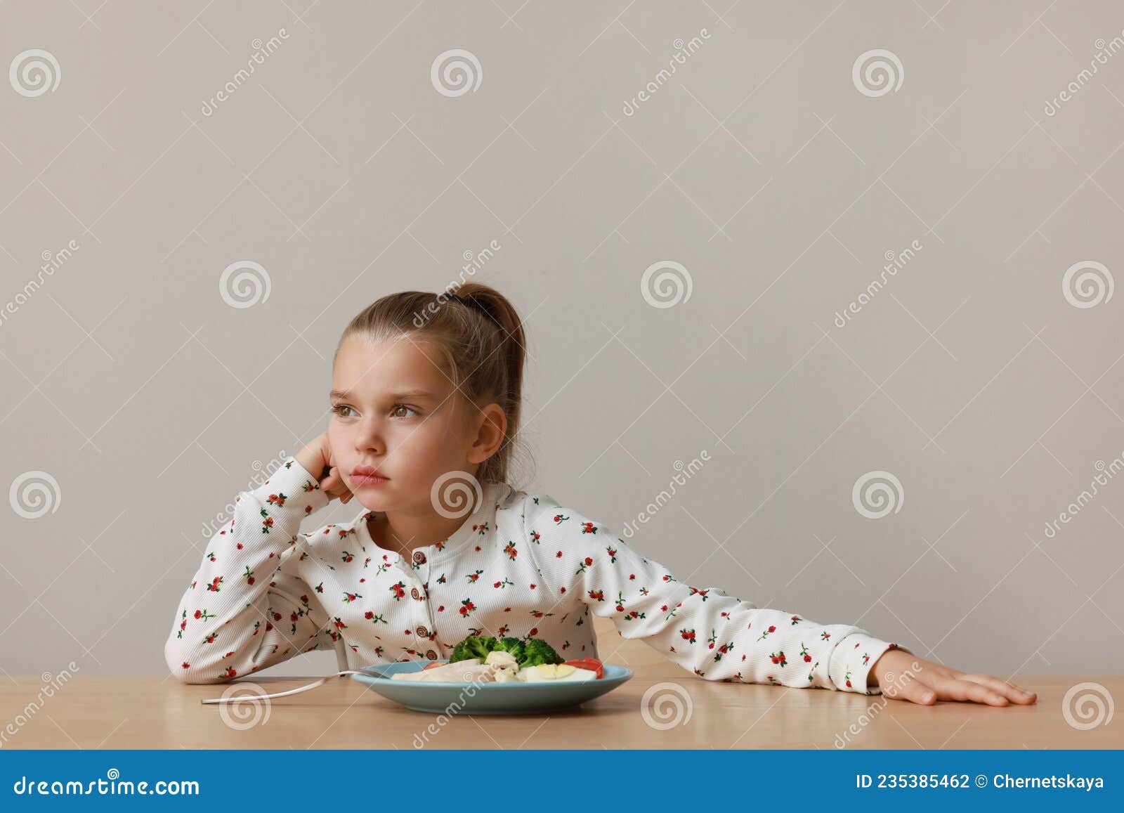 Cute Little Girl Refusing To Eat Her Dinner at Table on Grey Background ...