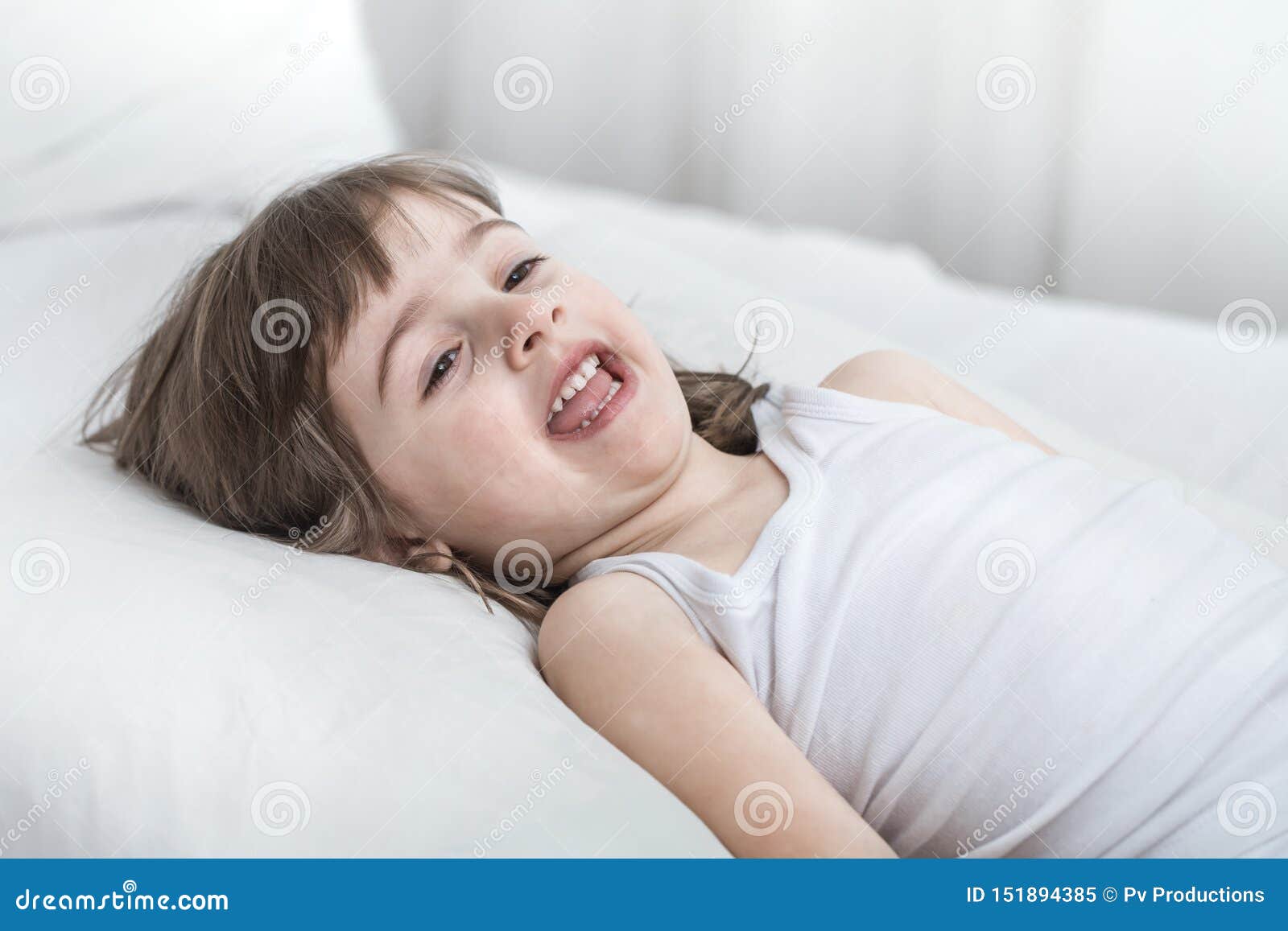 Cute Little Girl Smiling while Lying in a Cozy White Bed Stock Image ... Cute Little Girl Smiling while Lying in a Cozy White Bed Stock Image ...