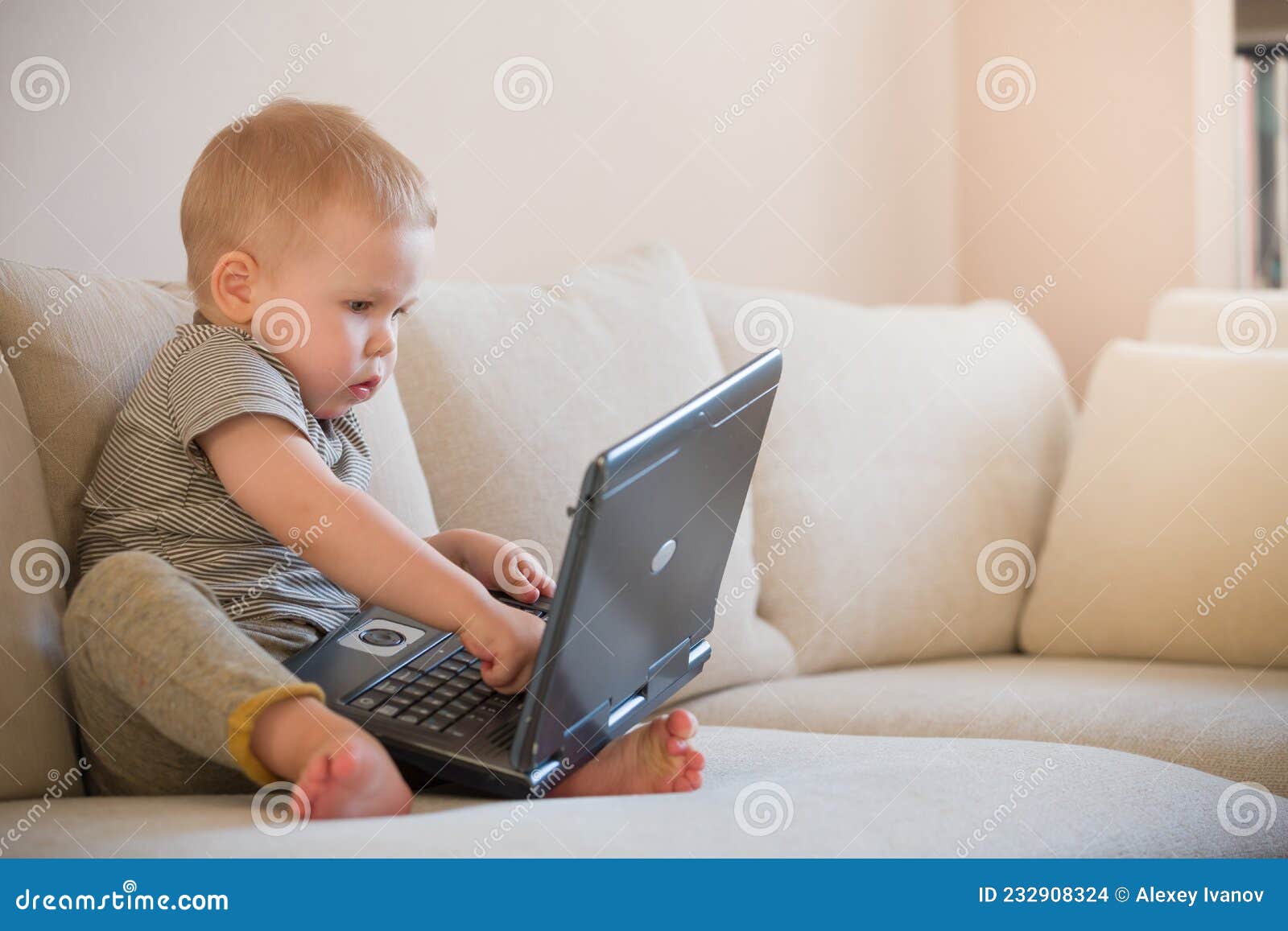 Cute Little Toddler Boy Sitting on the Sofa with His Laptop and Looking ...