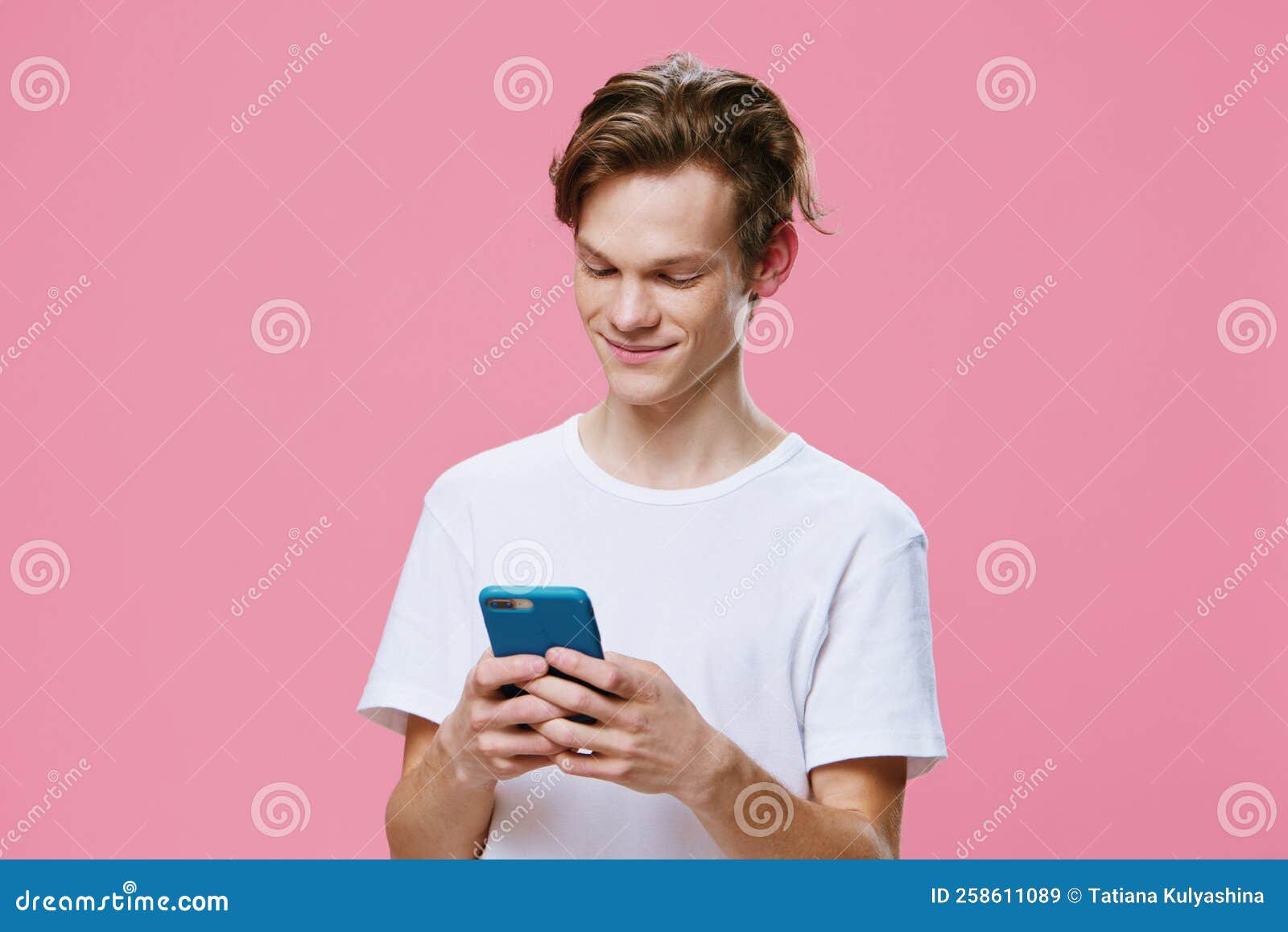 Cute Nice Guy with a Thoughtful Smile Typing a Text Message on the ...