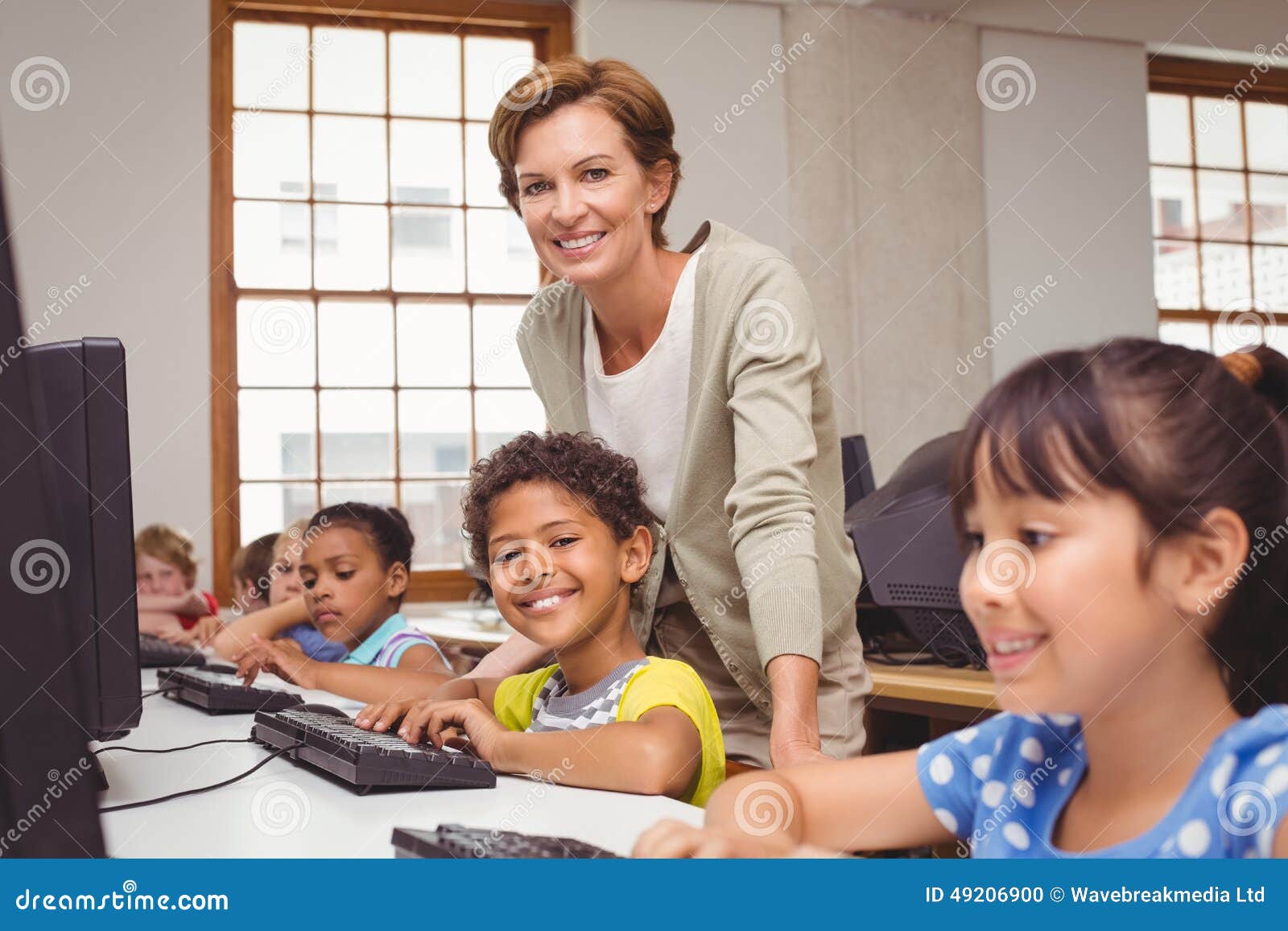 Cute Pupil in Computer Class with Teacher Smiling at Camera Stock Photo ...