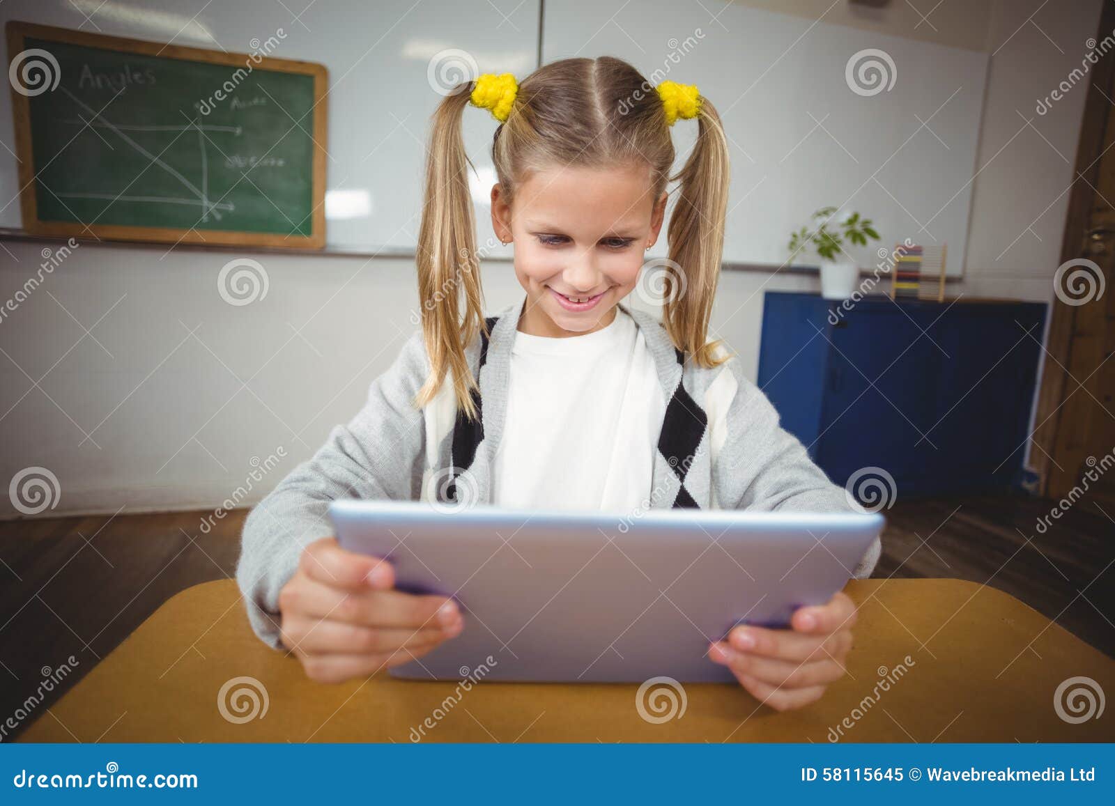 Cute Pupil Using Tablet at Her Desk in a Classroom Stock Image - Image ...