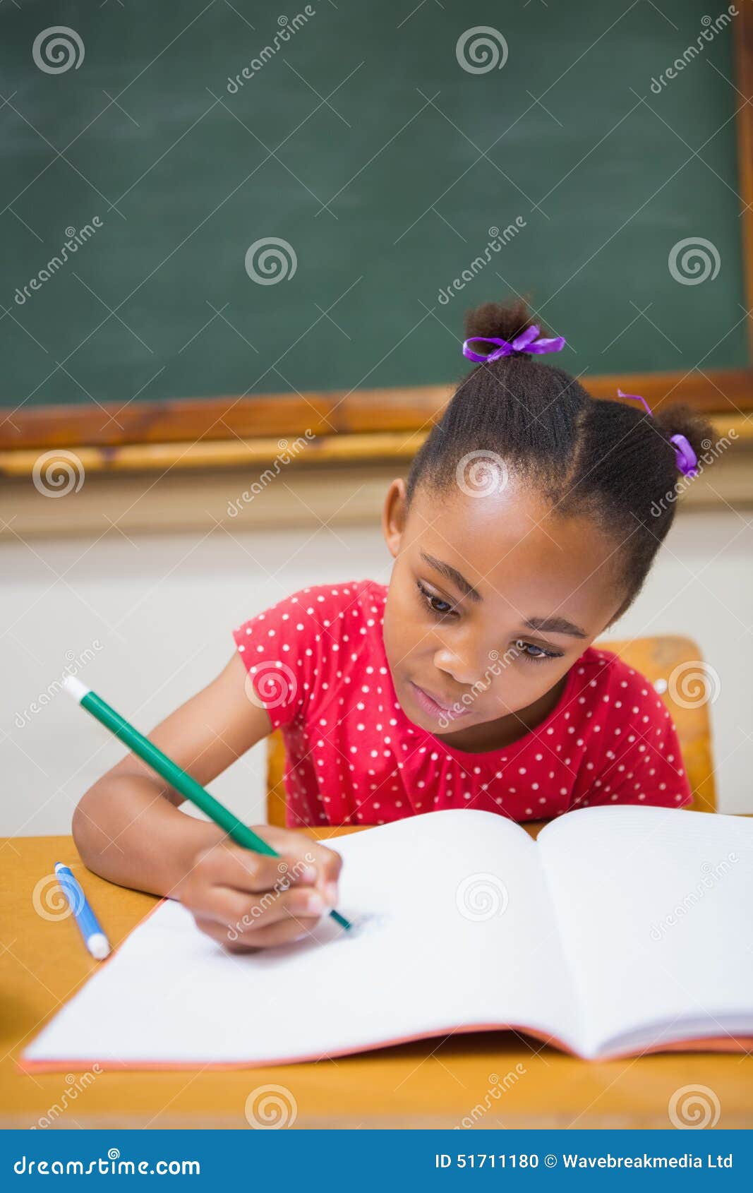 Cute Pupil Writing at Desk in Classroom Stock Photo - Image of ...
