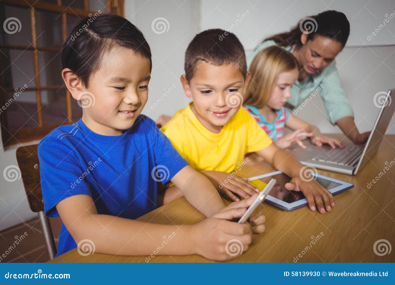 Cute Pupils in Class Using Laptop and Tablet Stock Photo - Image of ...