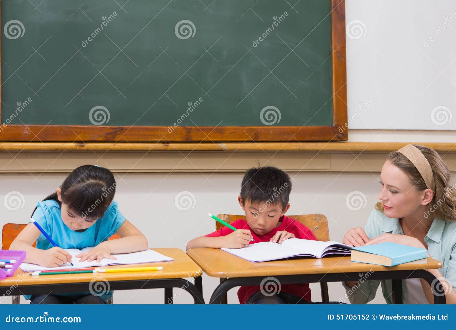 Cute Pupils Getting Help from Teacher in Classroom Stock Photo - Image ...