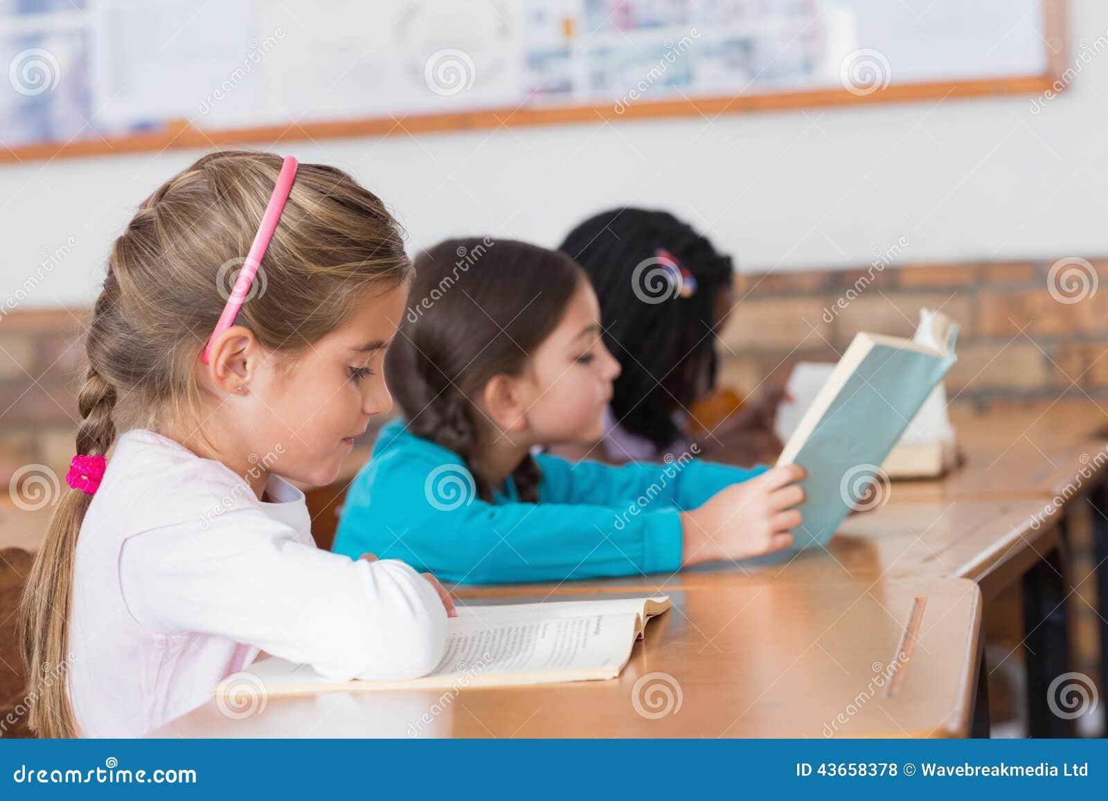 Cute Pupils Reading Books at Their Desks Stock Photo - Image of ...