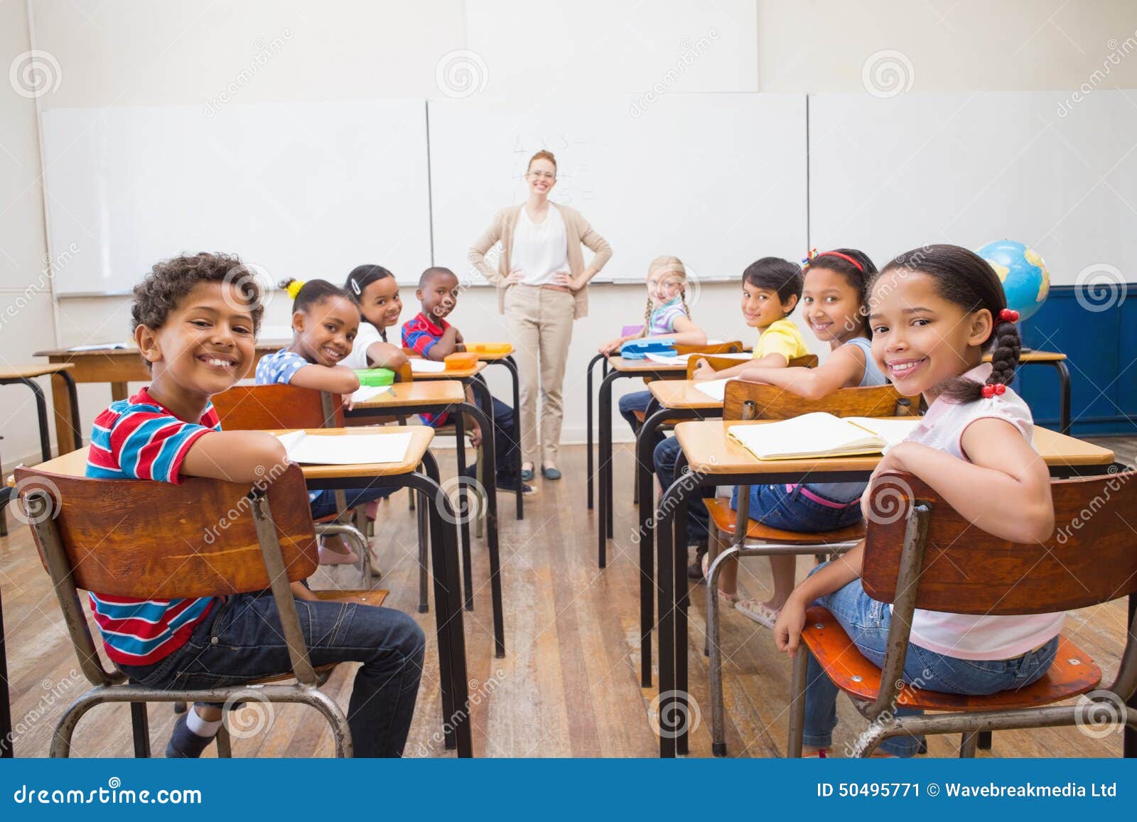 Cute Pupils Smiling at Camera in Classroom Stock Image - Image of back ...