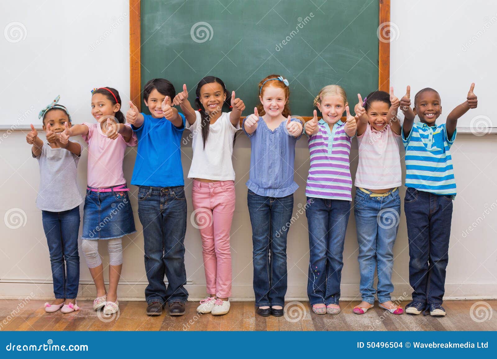 Cute Pupils Smiling at Camera in Classroom Stock Photo - Image of line ...