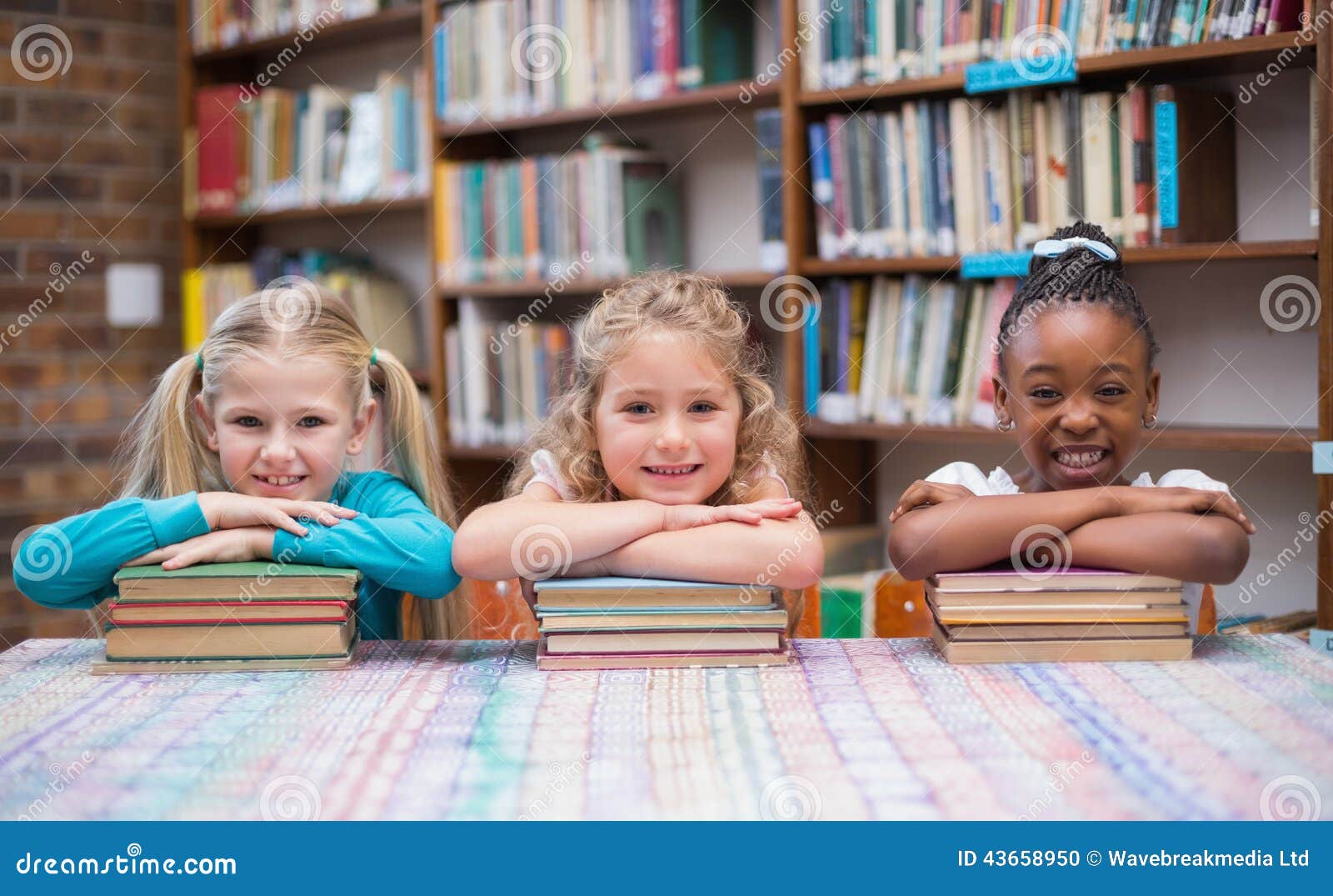 Cute Pupils Smiling at Camera in Library Stock Photo - Image of ...