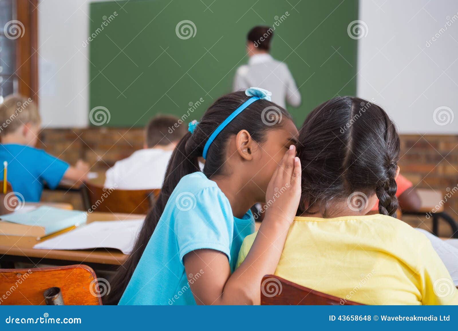 Cute Pupils Whispering in Classroom Stock Photo - Image of rear, woman ...