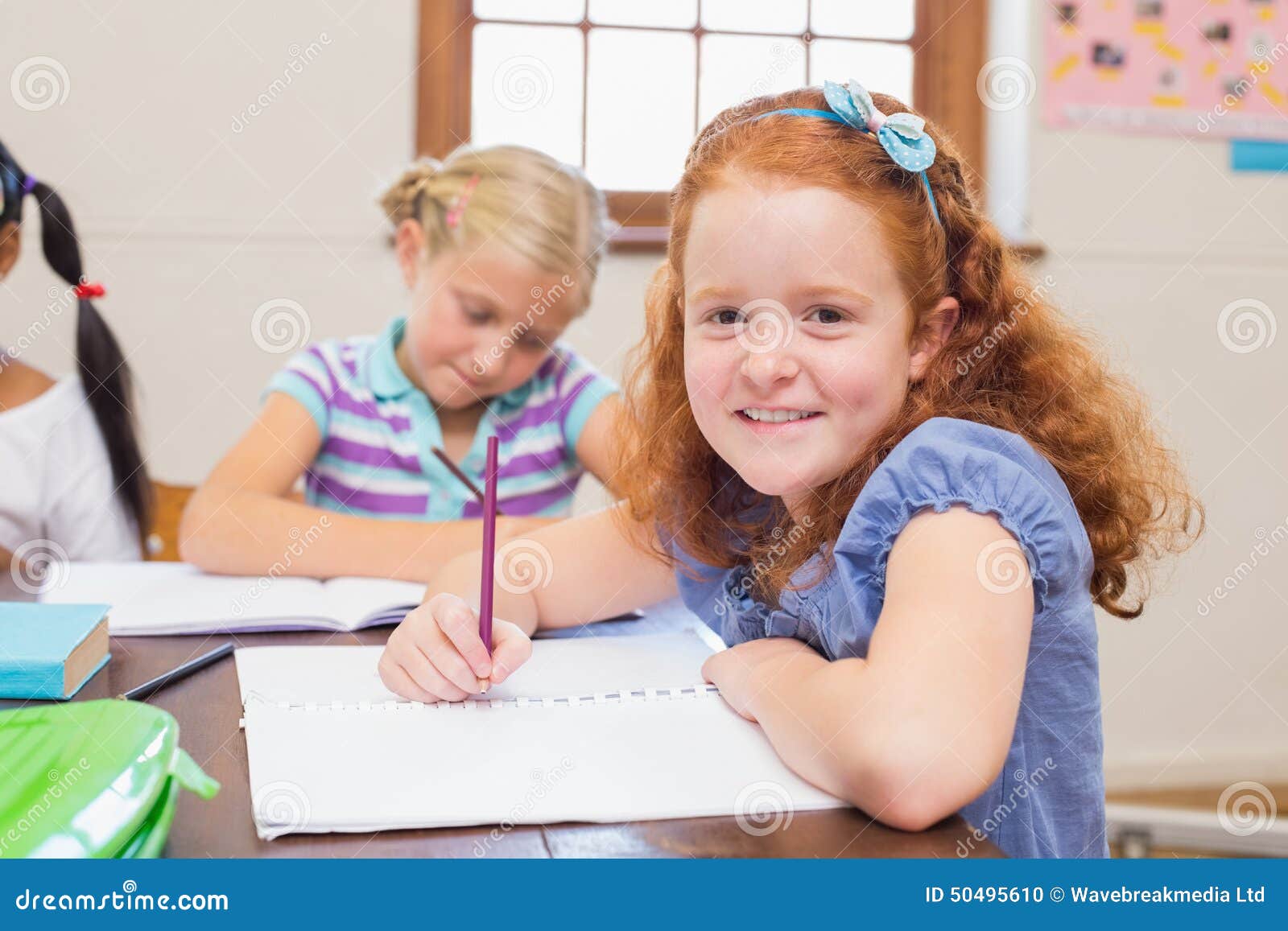 Cute Pupils Writing at Desk in Classroom Stock Photo - Image of ...