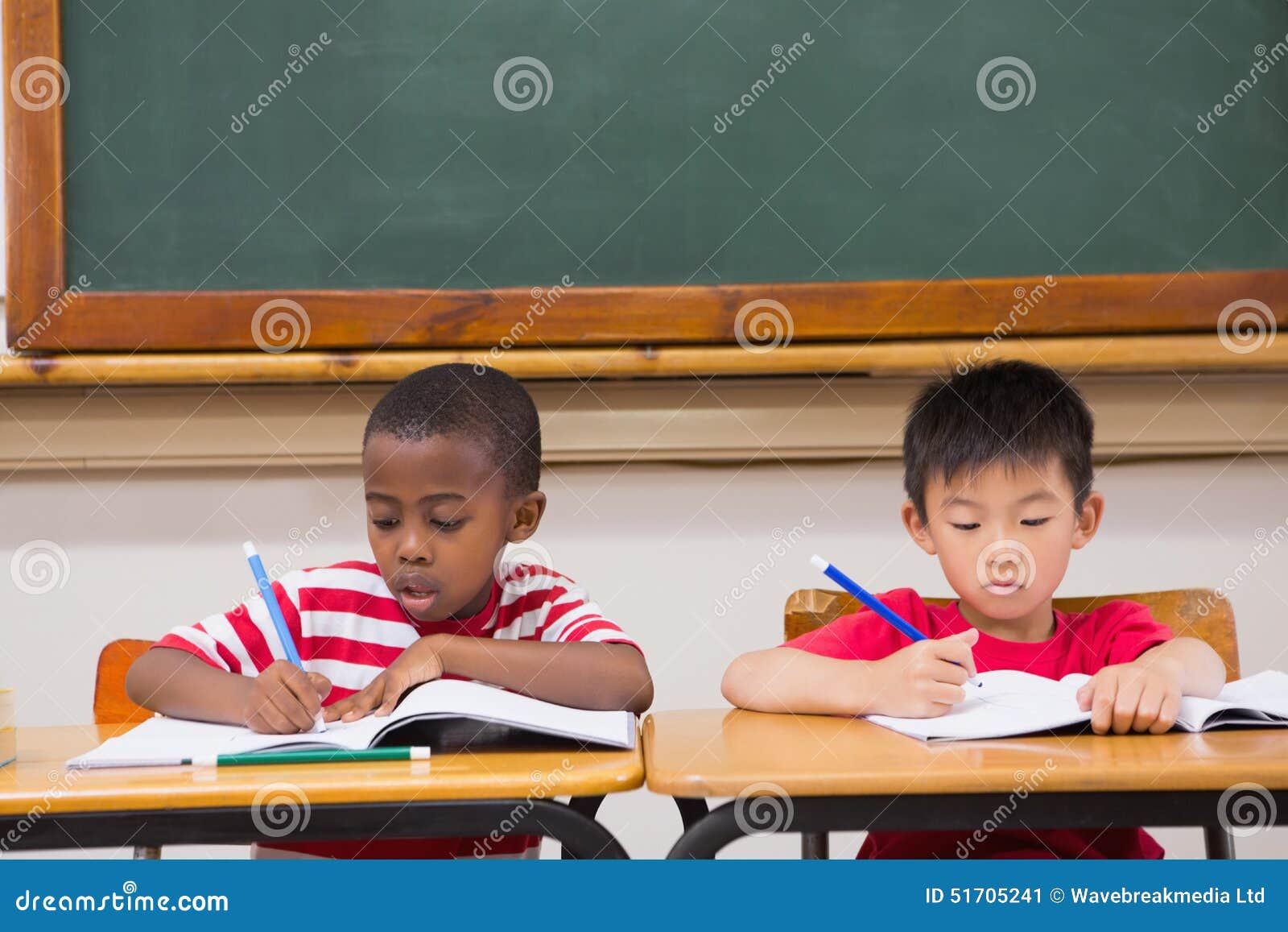 Cute Pupils Writing at Desk in Classroom Stock Image - Image of cute ...