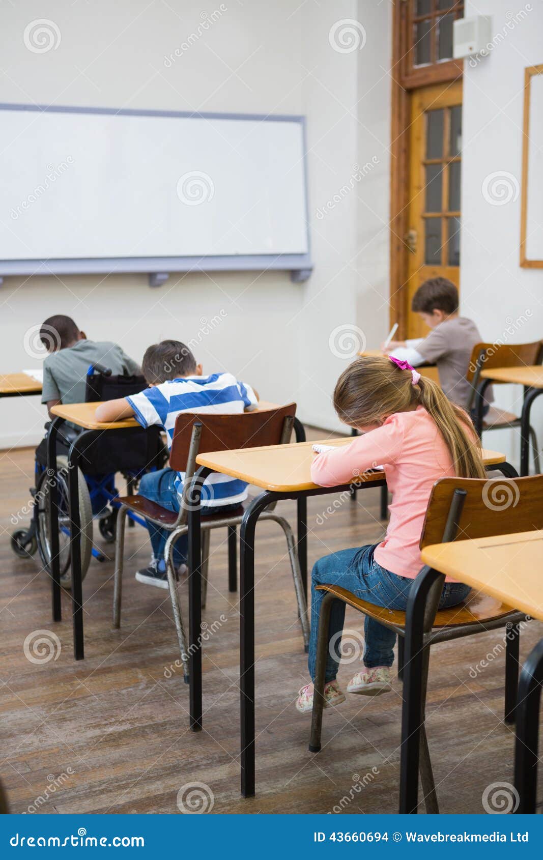 Cute Pupils Writing at Desks in Classroom Stock Photo - Image of learn ...
