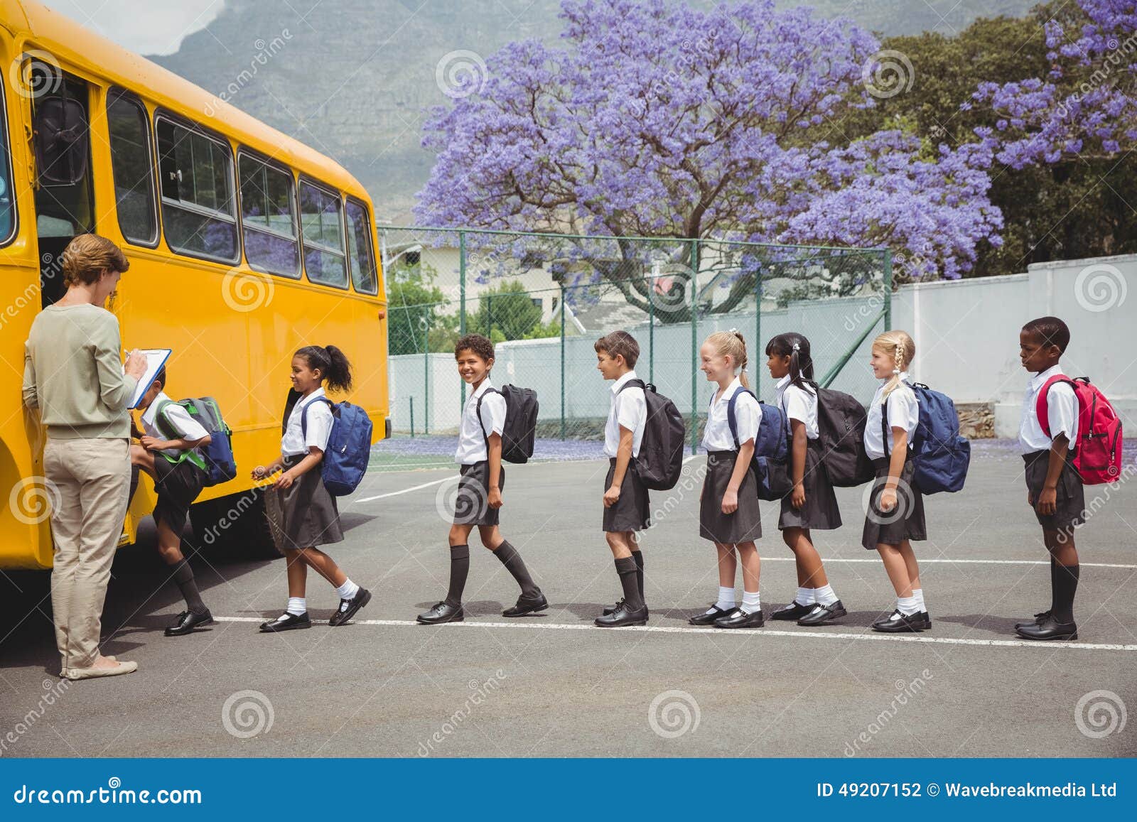 Cute Schoolchildren Waiting To Get On School Bus Stock Photo - Image ...