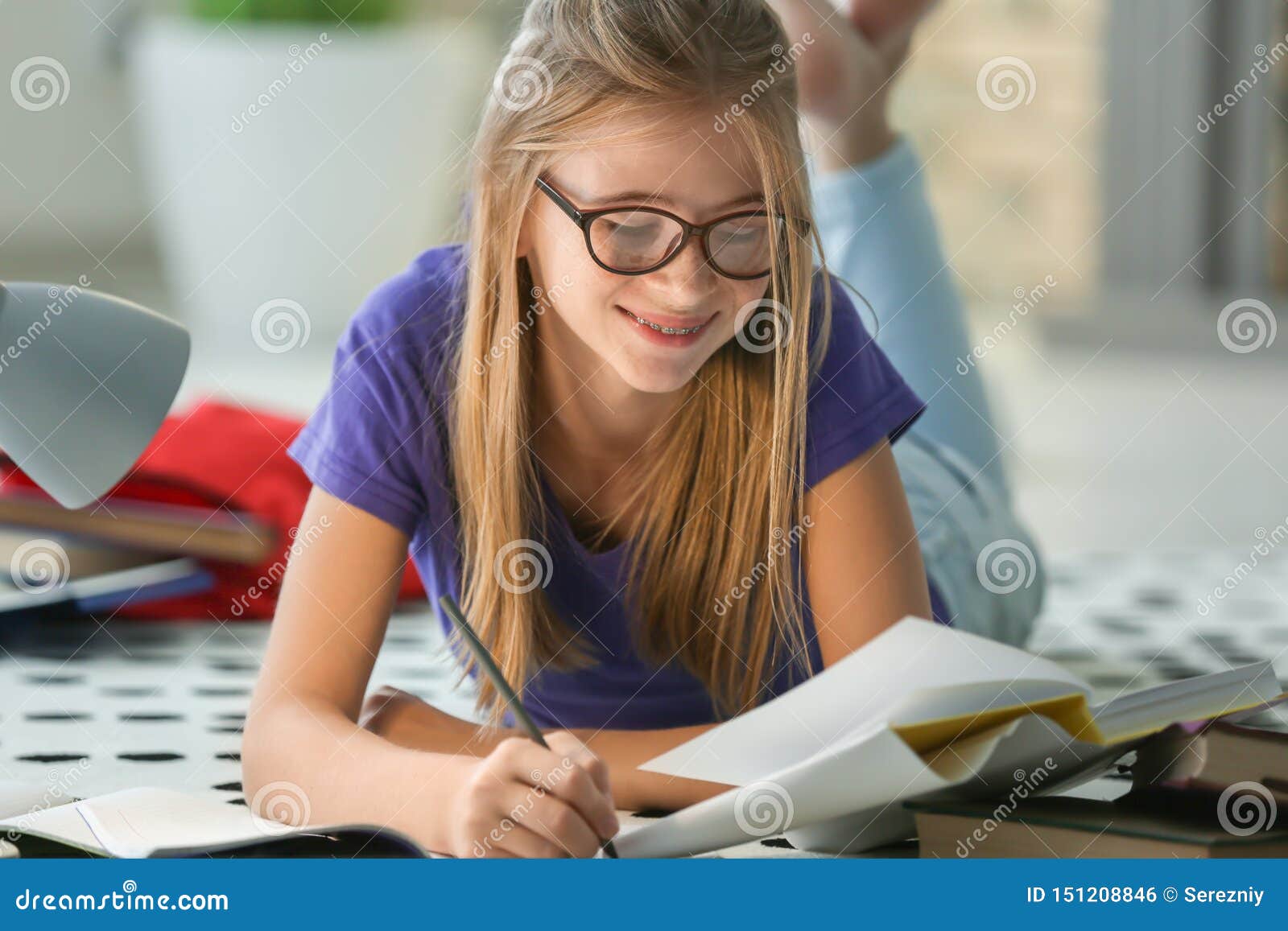 Cute Schoolgirl Doing Homework while Lying on Floor Indoors Stock Photo ...