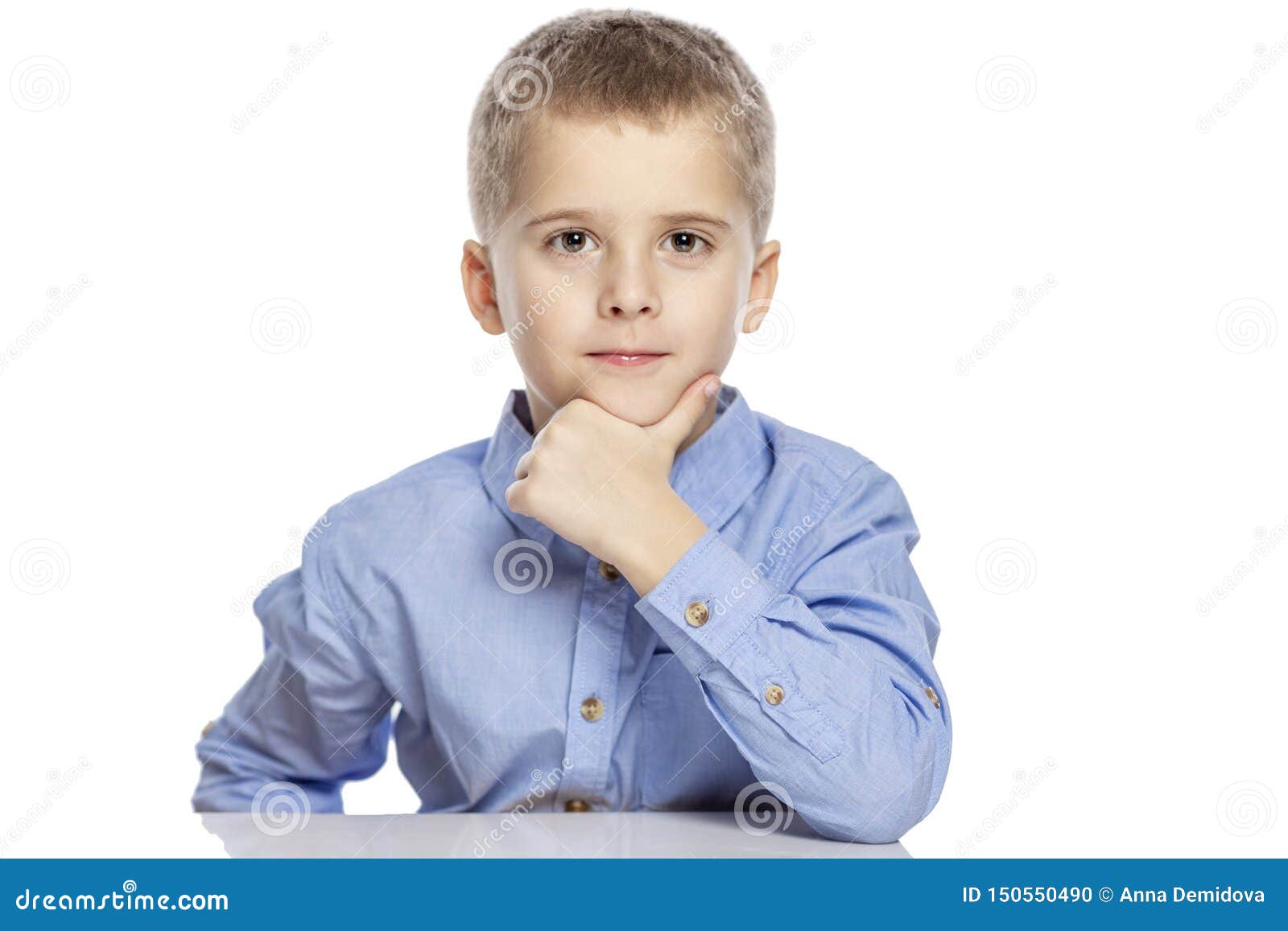 Cute Serious Boy of School Age Sits at the Table. Isolated on a White ...