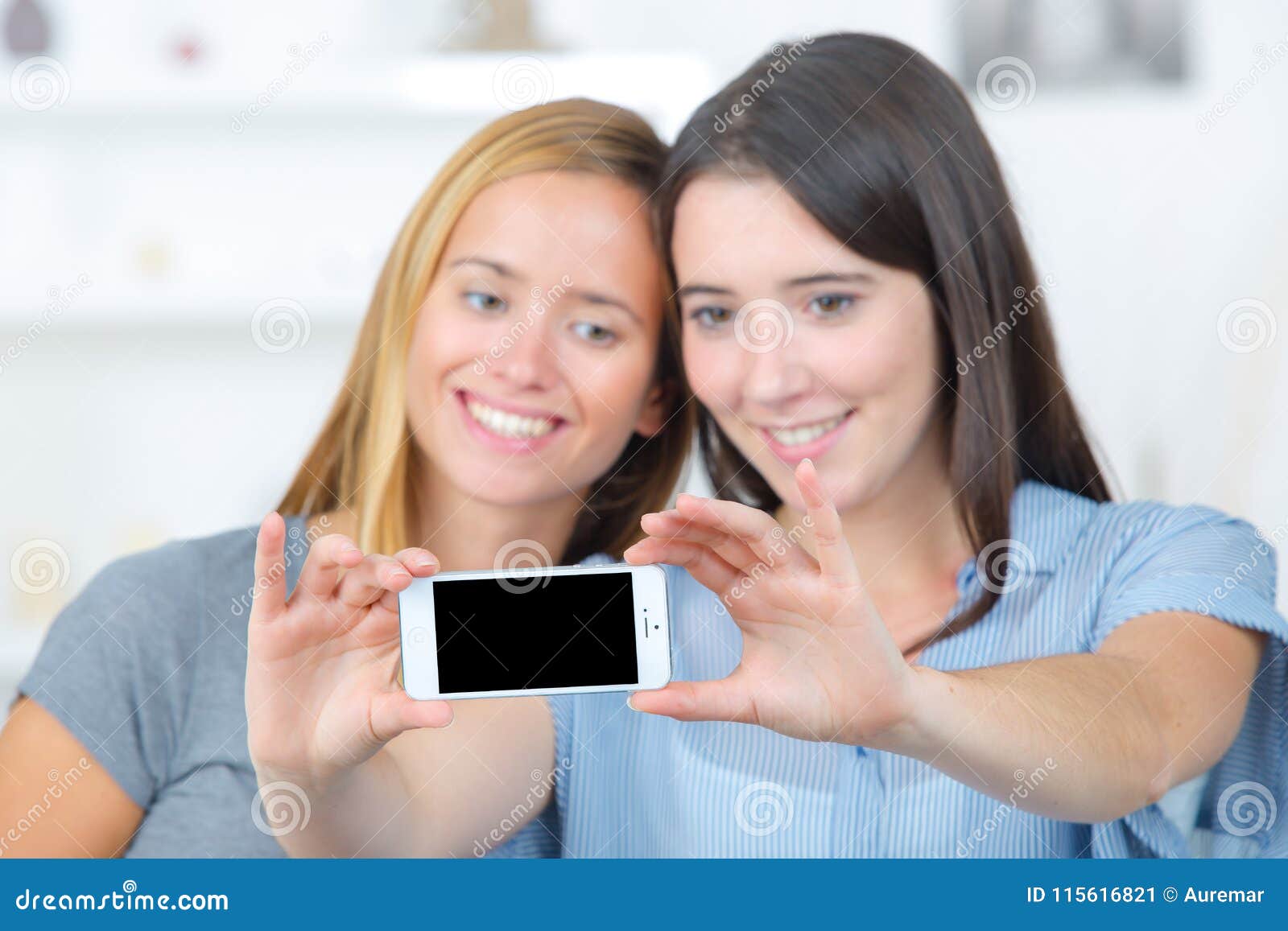 Cute Sisters Pouting While Taking Photos With Smart Phone Stock Image