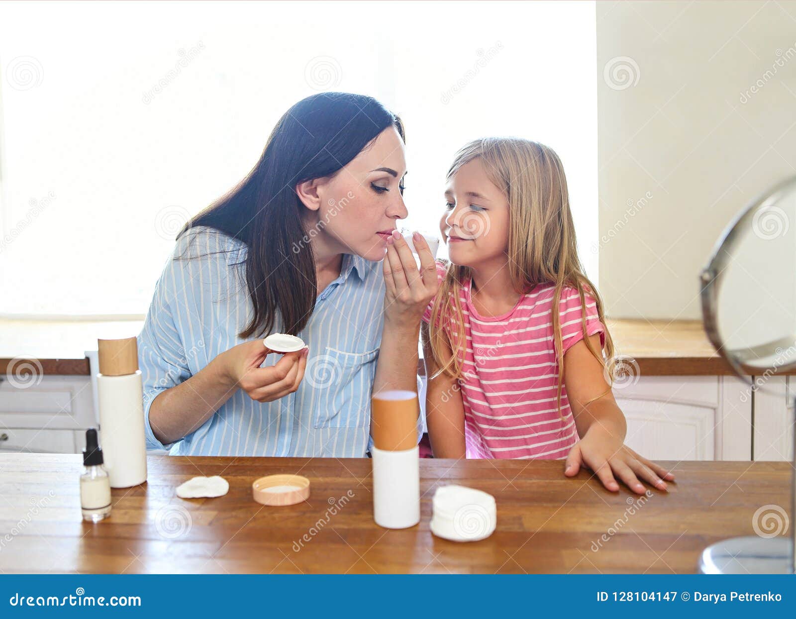 Cute Smiling Mother And Daughter Applying Face Cream Stock Image