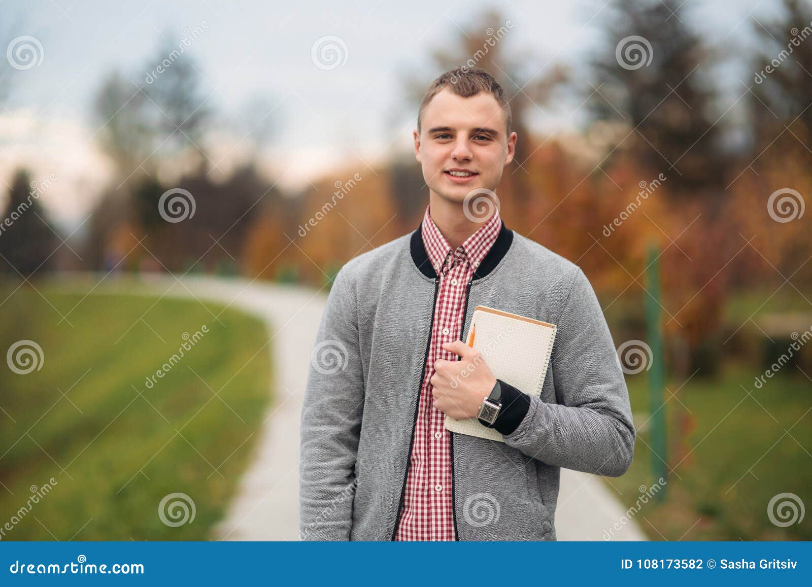 A Cute Student Writes Down His Thoughts in His Notebook Using a Pencil ...