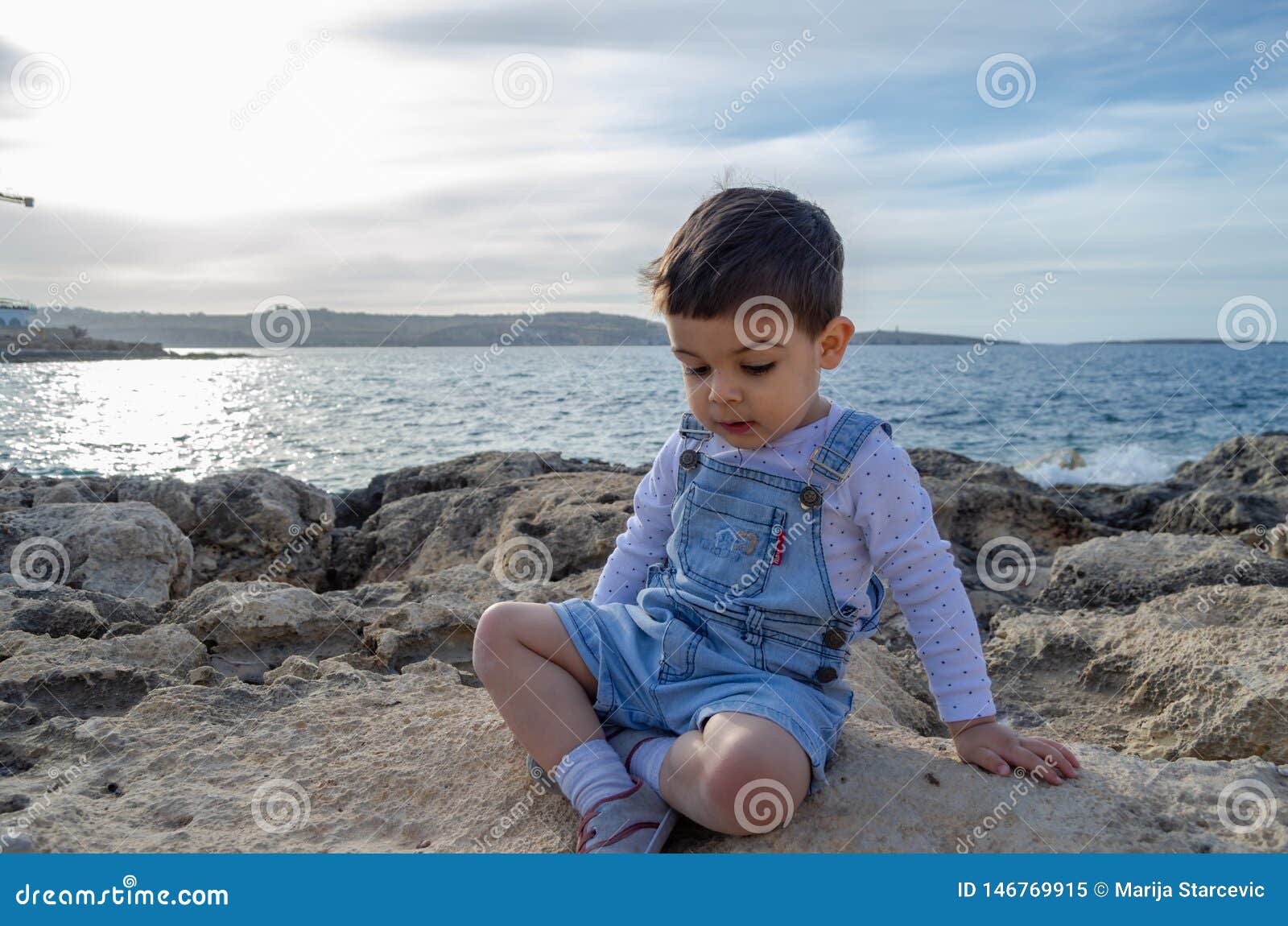 Cute Two Years Old Boy Sitting on the Rocks on the Sea Stock Image ...