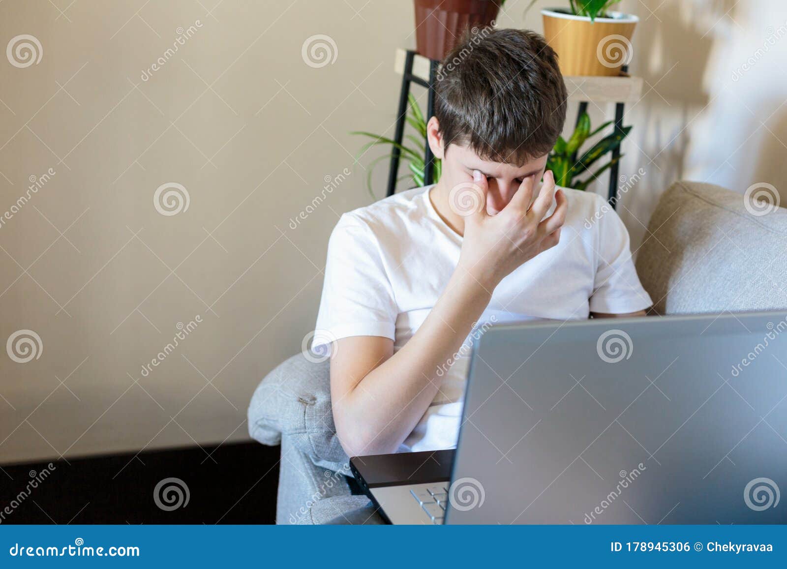 Cute Upset Boy in White T Shirt Sitting on the Couch in the Living Room ... Cute Upset Boy in White T Shirt Sitting on the Couch in the Living Room ...